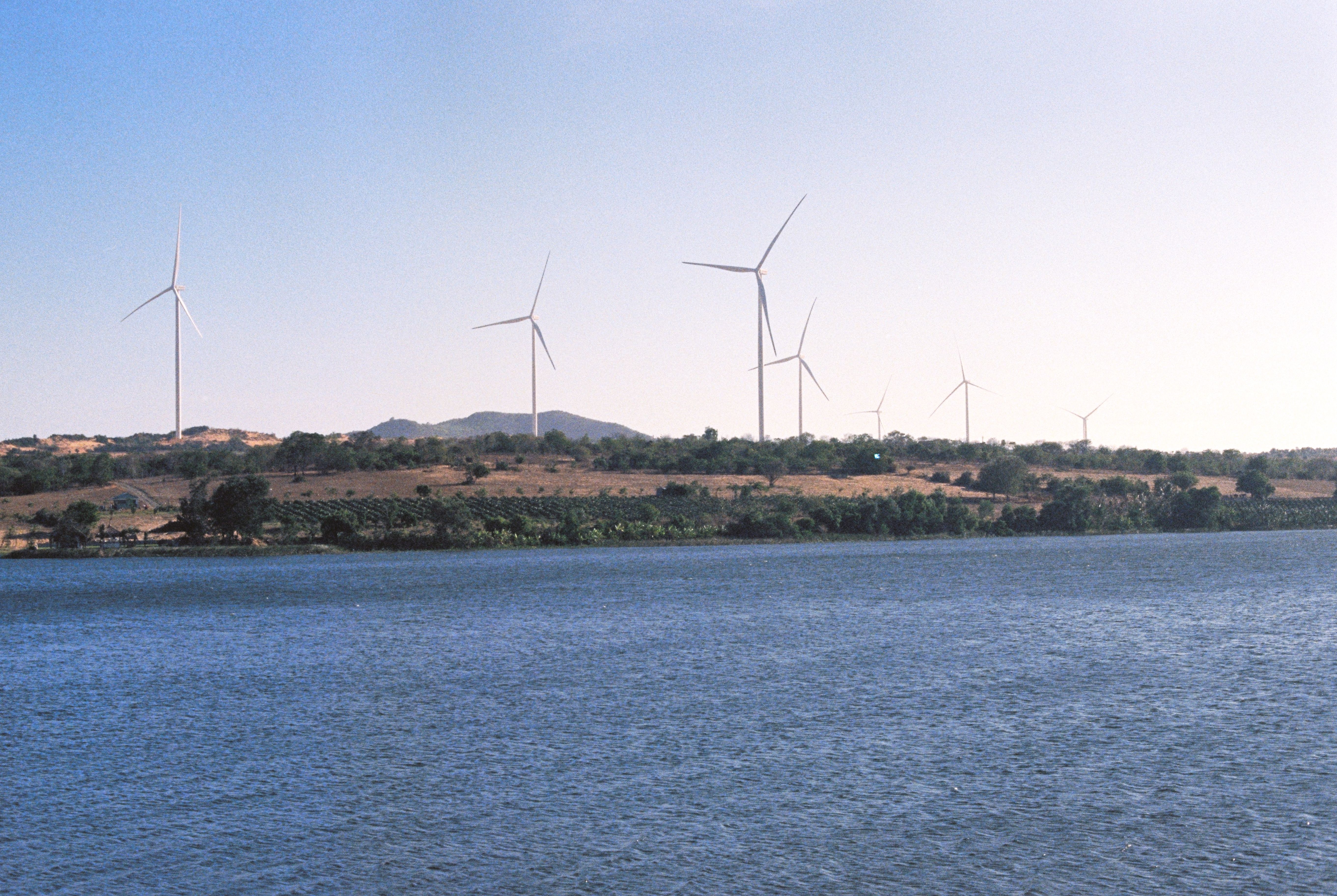 Scenic Landscape with Wind Turbines by Water · Free Stock Photo