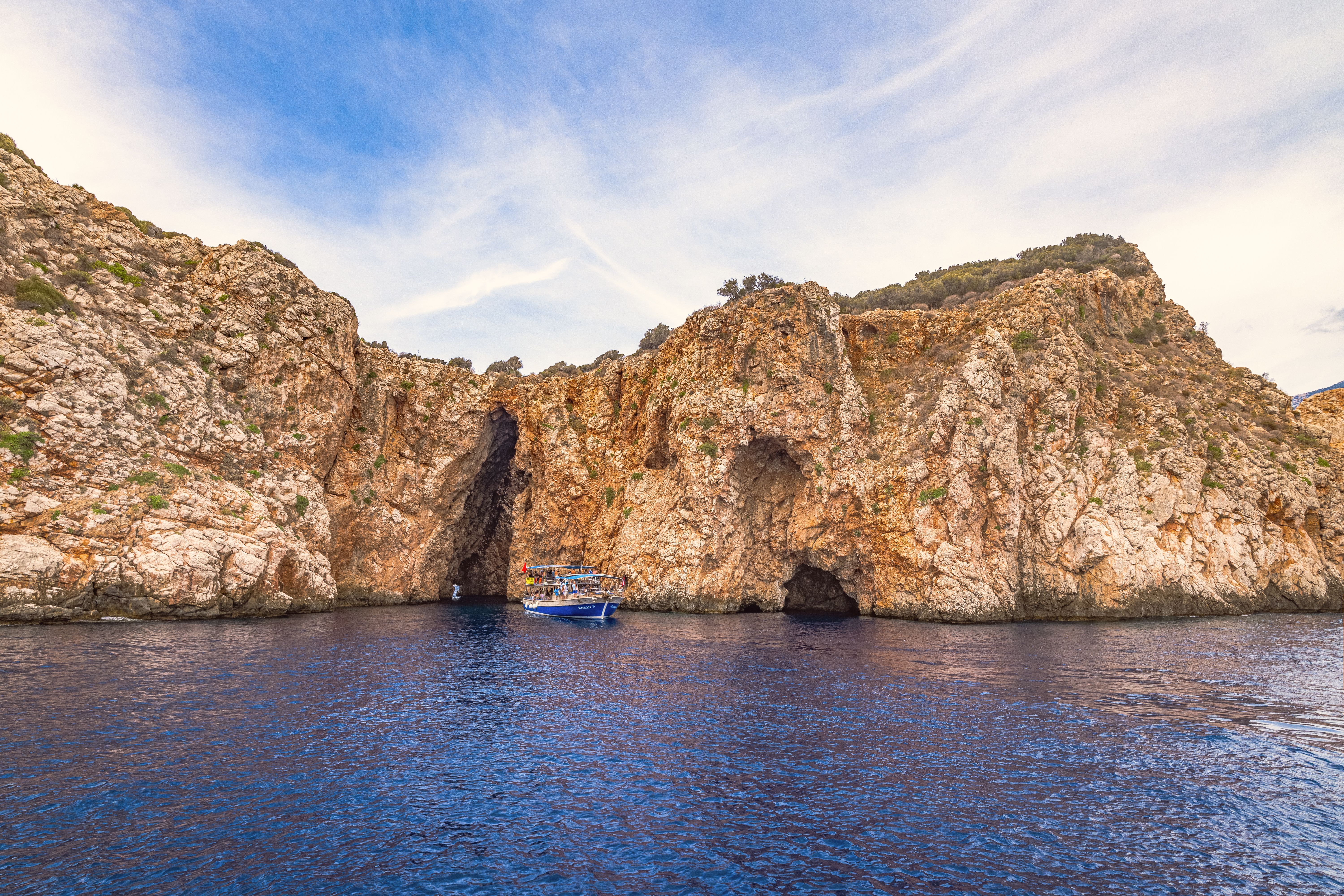 Scenic Coastal Cliffs with a Boat in Rocky Cove · Free Stock Photo