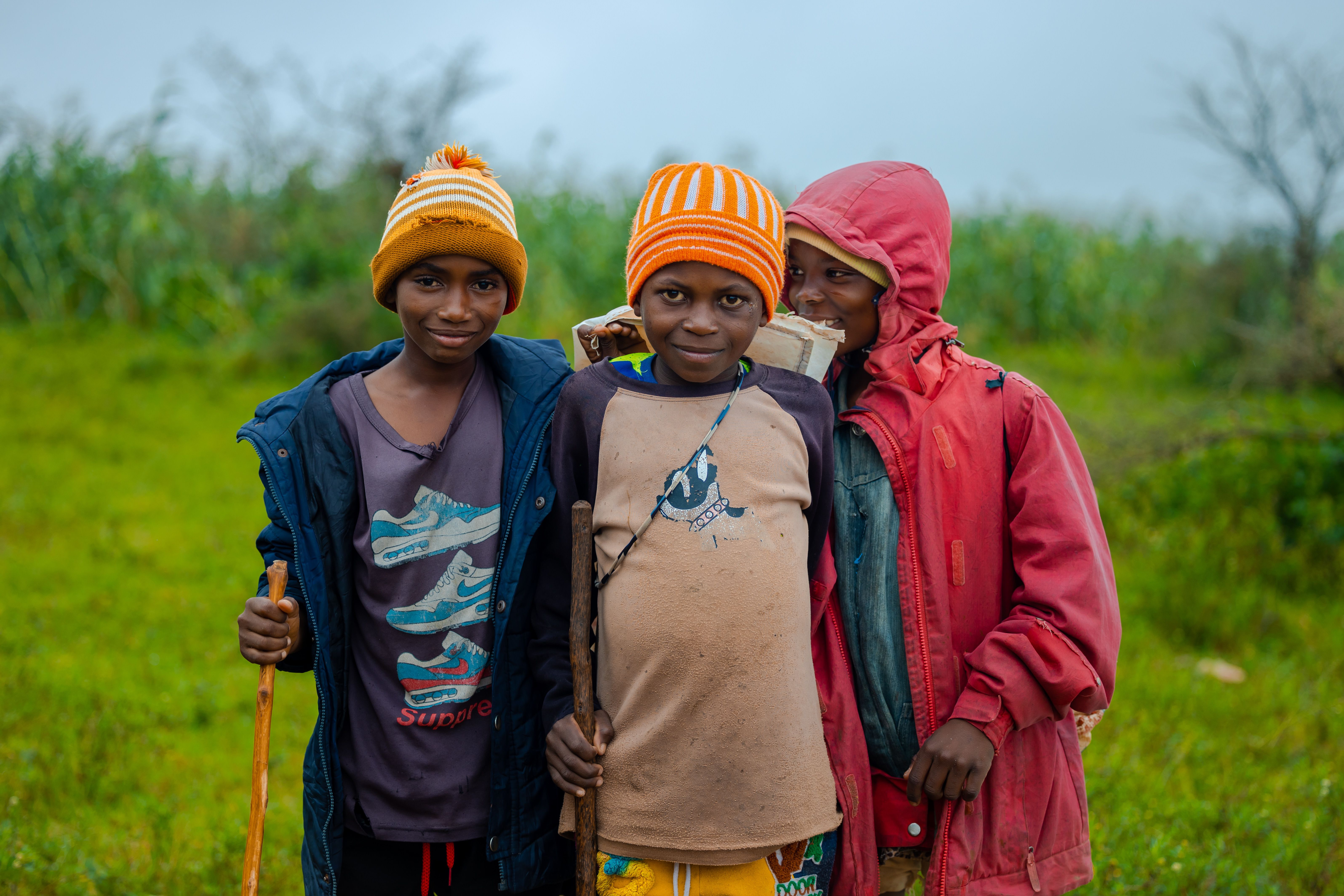 Three Boys in Colorful Jackets and Hats Outdoors · Free Stock Photo