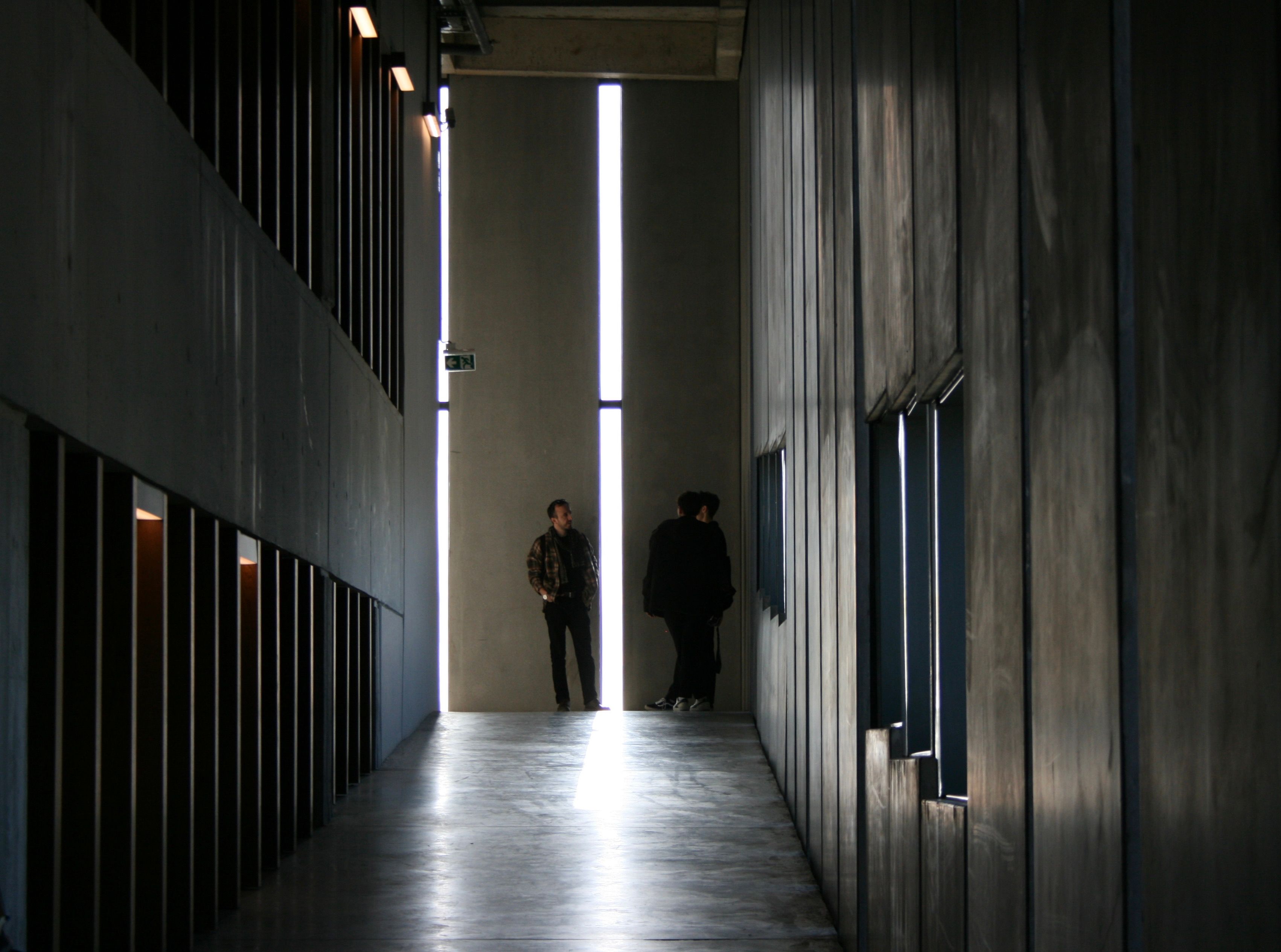 Dimly Lit Corridor with Two People Conversing · Free Stock Photo