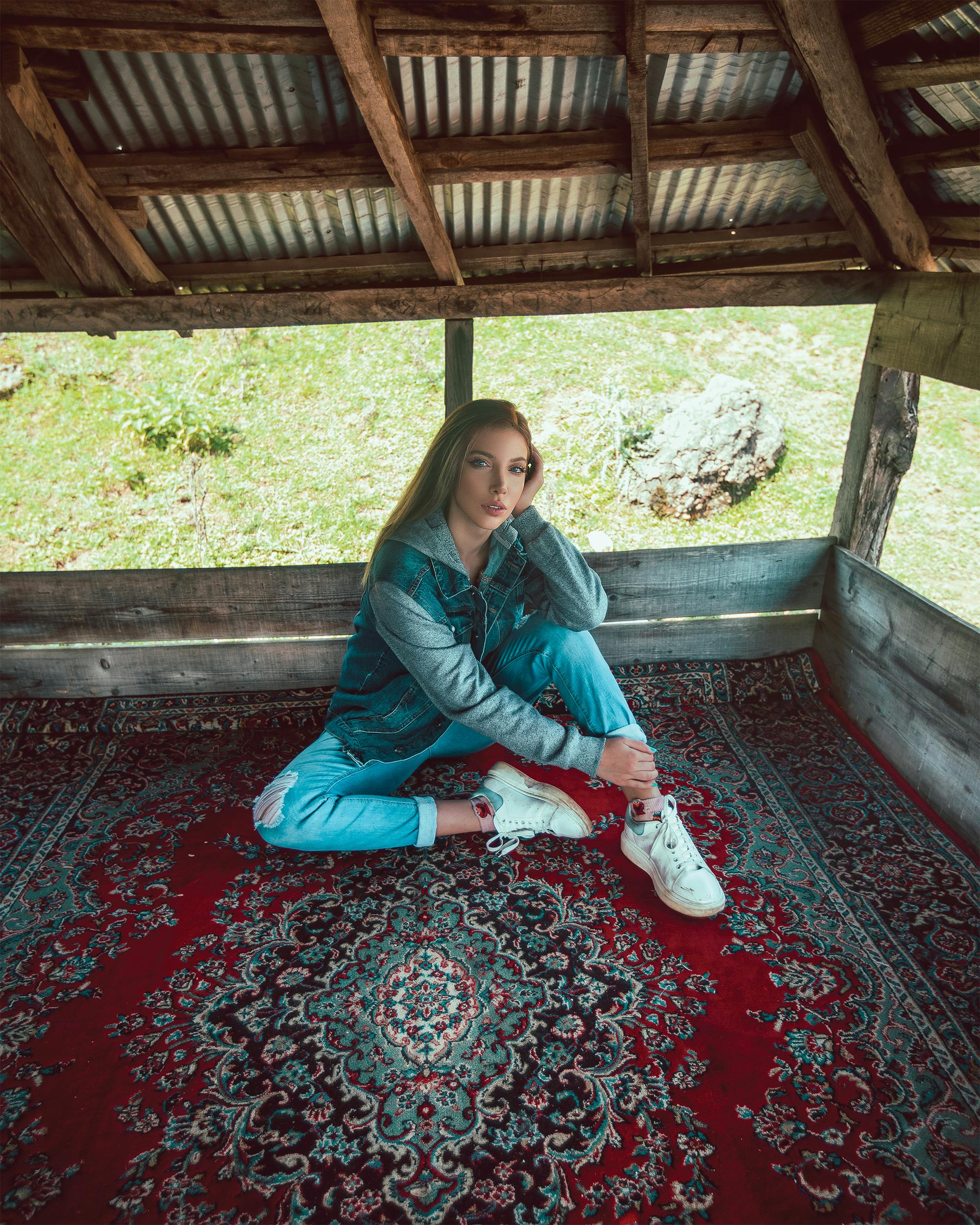 Woman in Denim Jacket Sitting on a Rug · Free Stock Photo