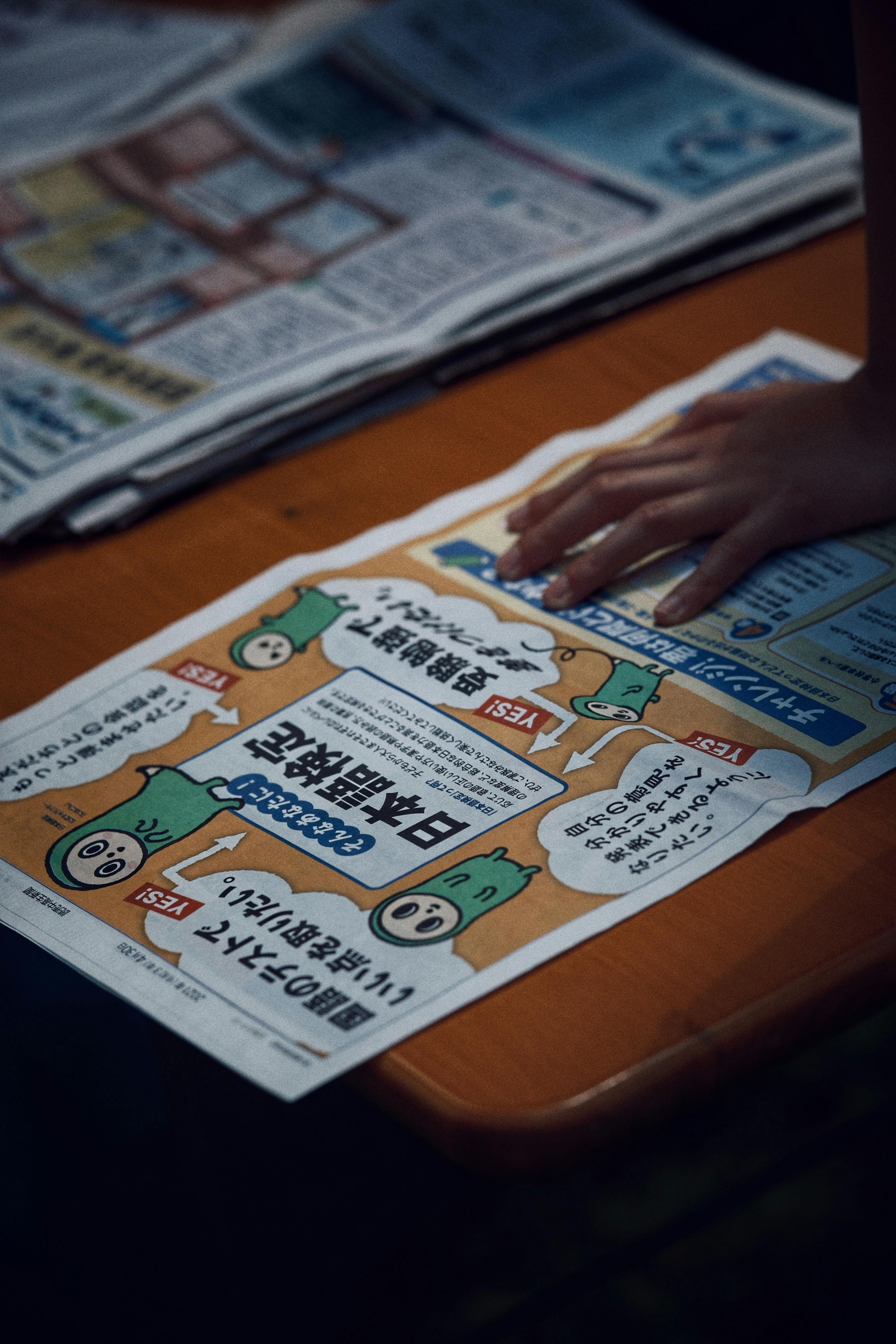 Hand holding newspaper with colorful graphics · Free Stock Photo