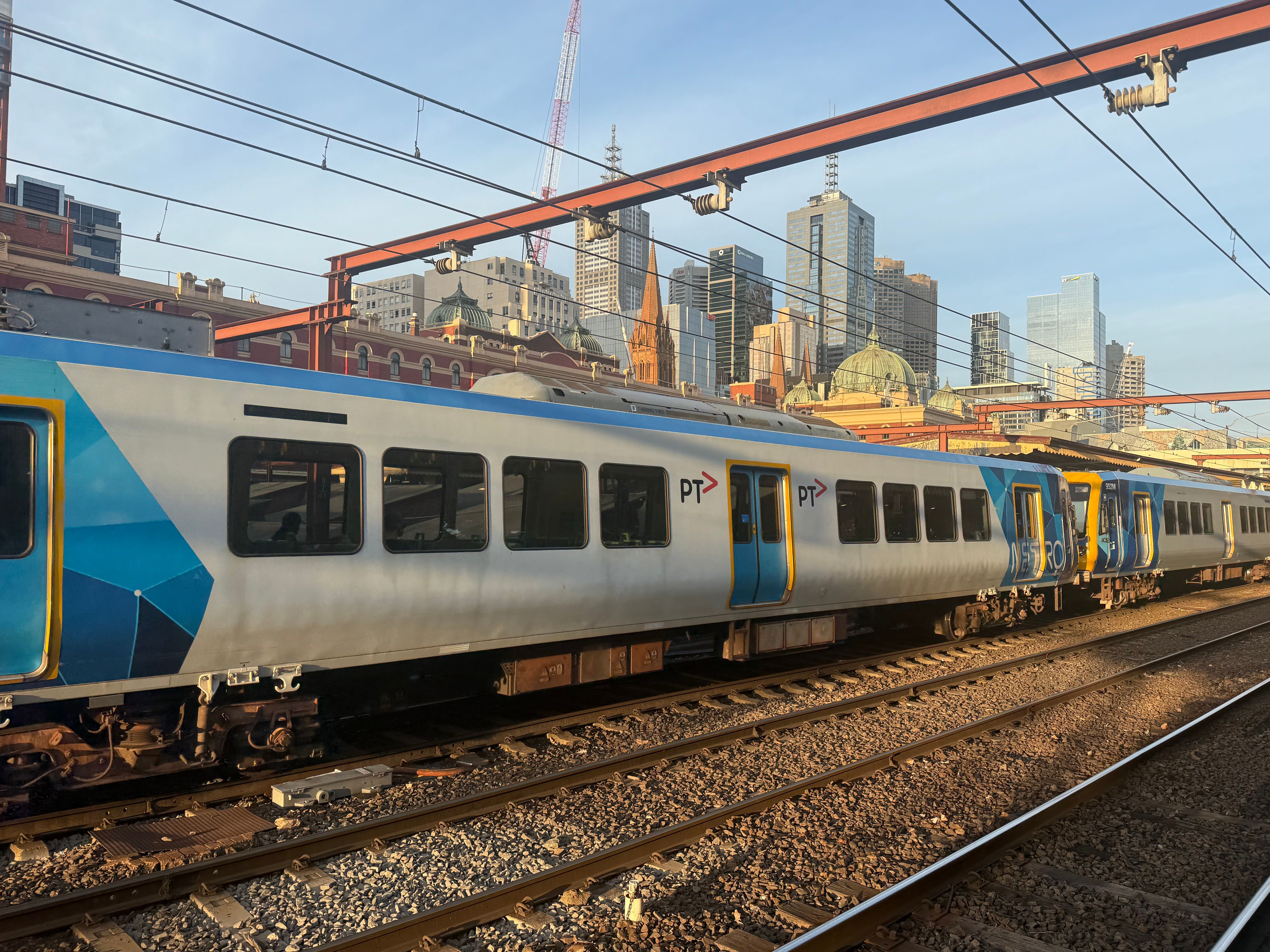 Commuter Train Next to Melbourne City Skyline · Free Stock Photo