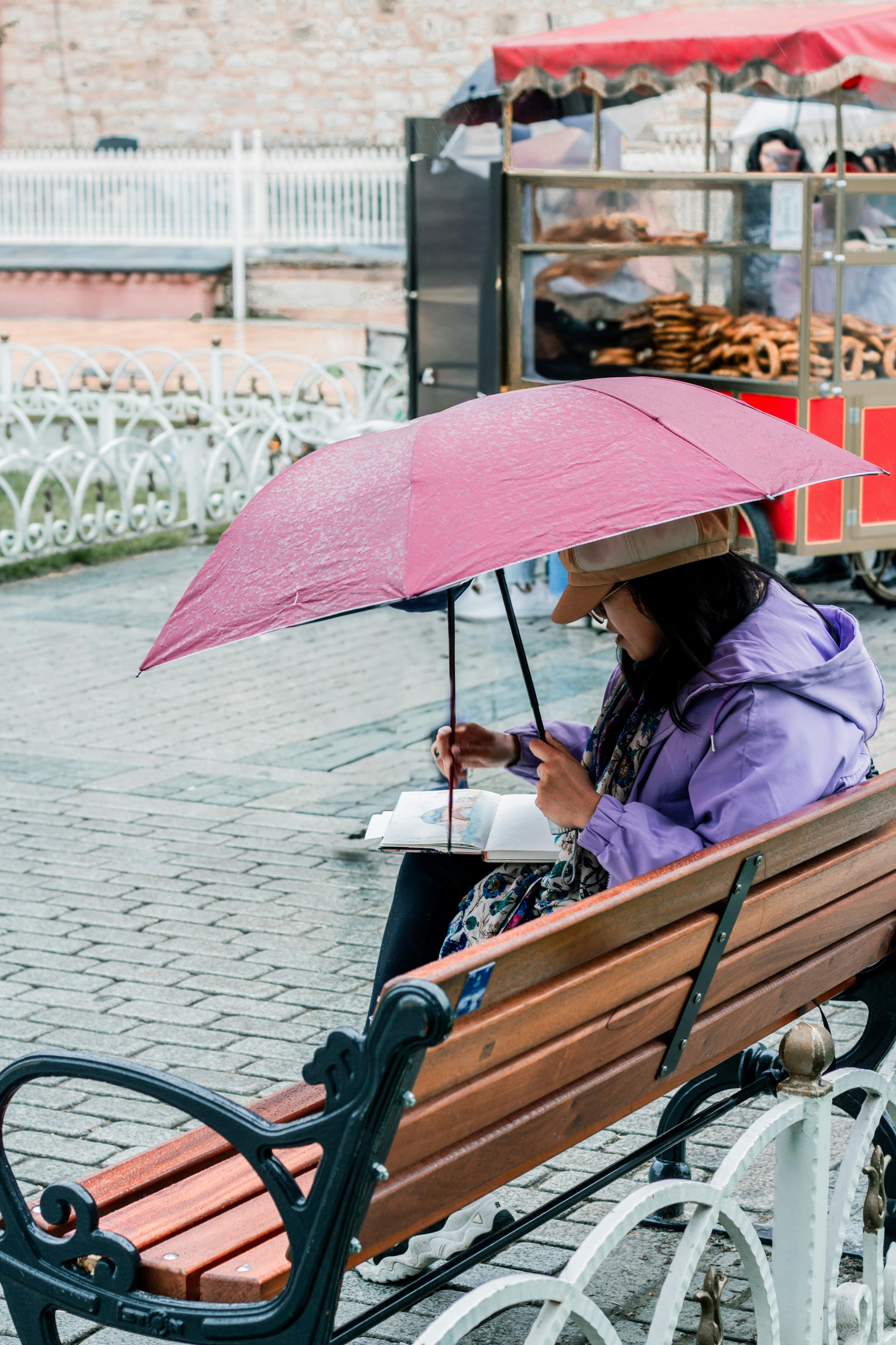 Woman Reading Under Umbrella on a Rainy Day · Free Stock Photo