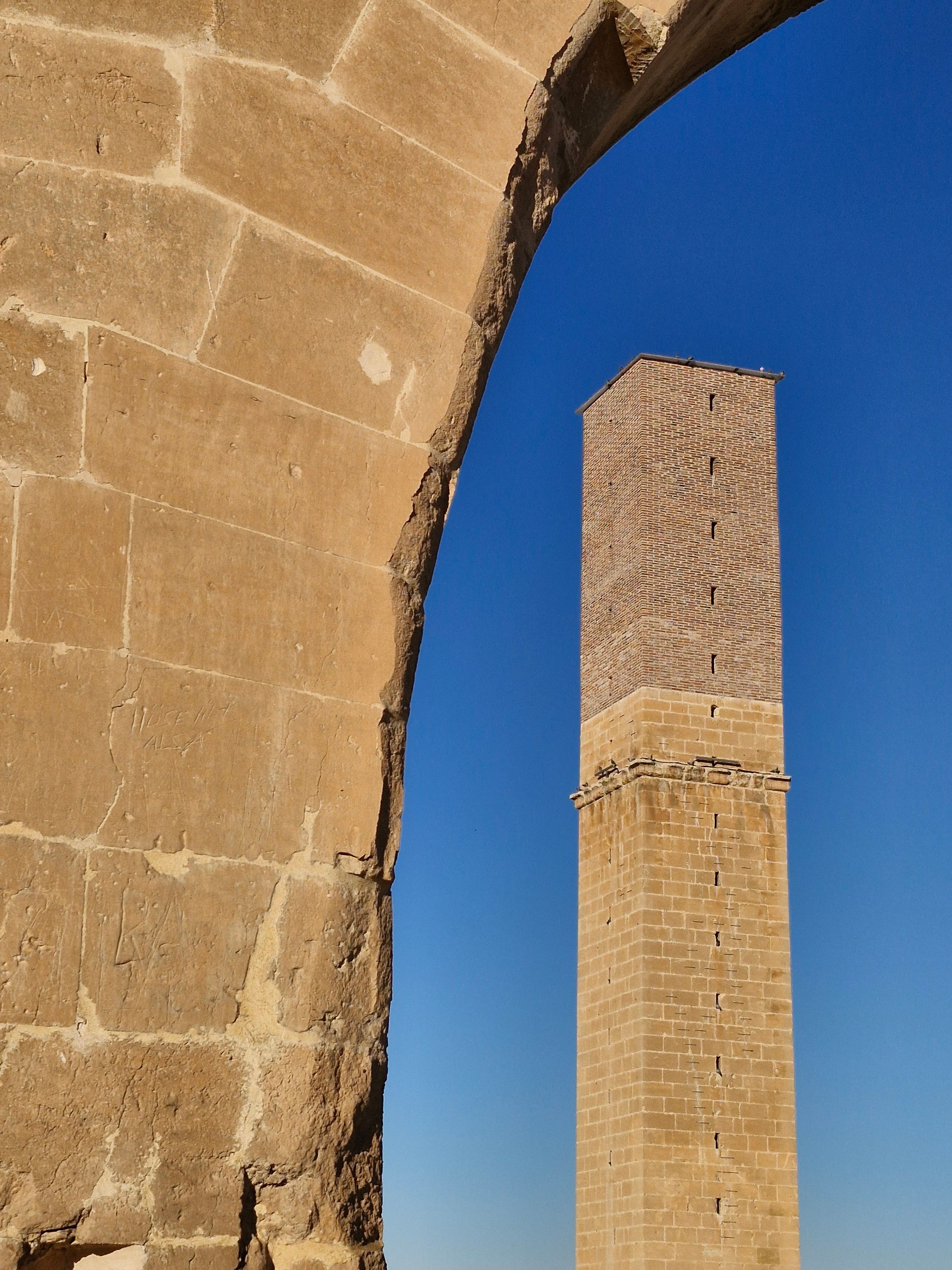 Tower and Ancient Arch Against Blue Sky · Free Stock Photo
