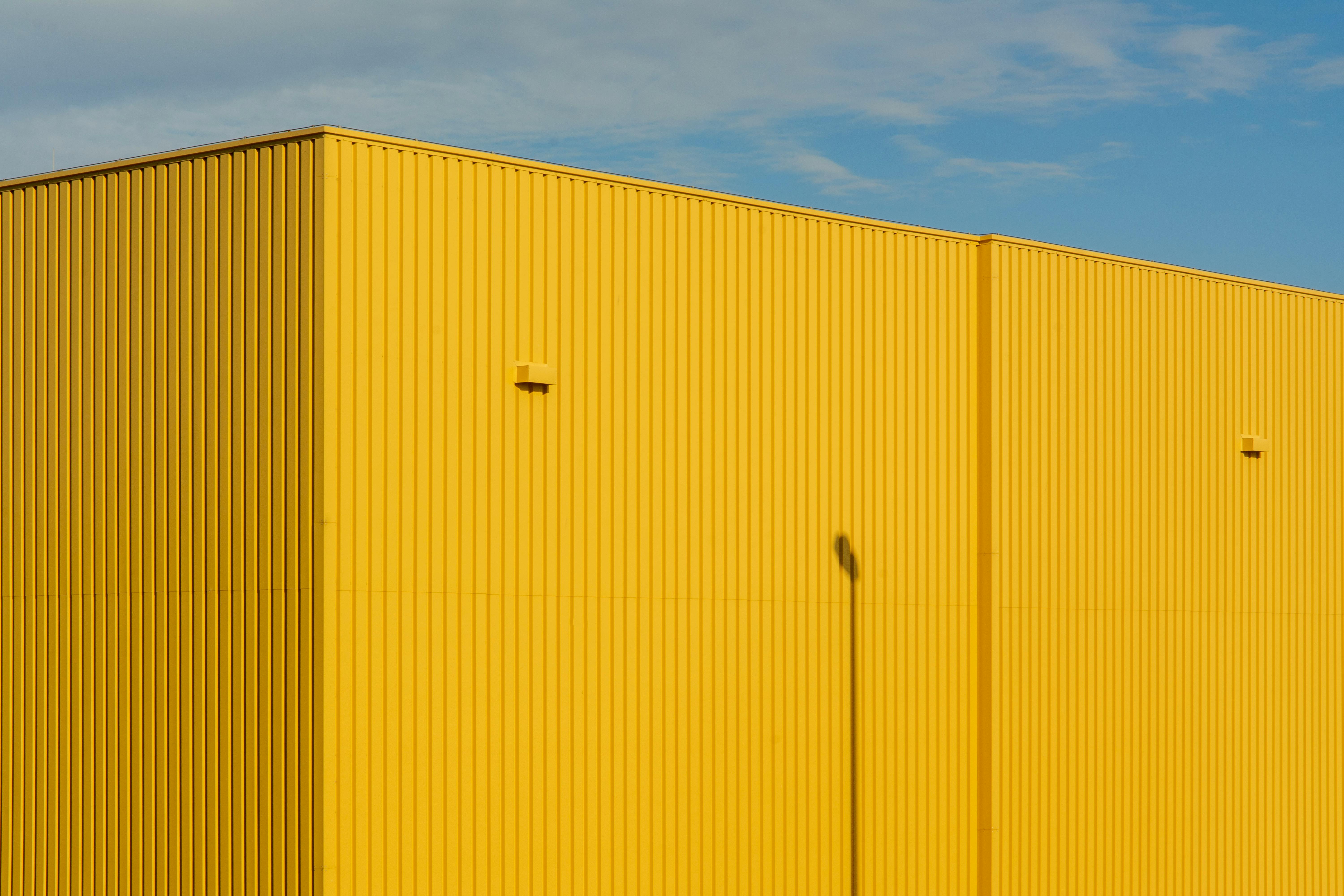 Vibrant Yellow Industrial Building Exterior · Free Stock Photo