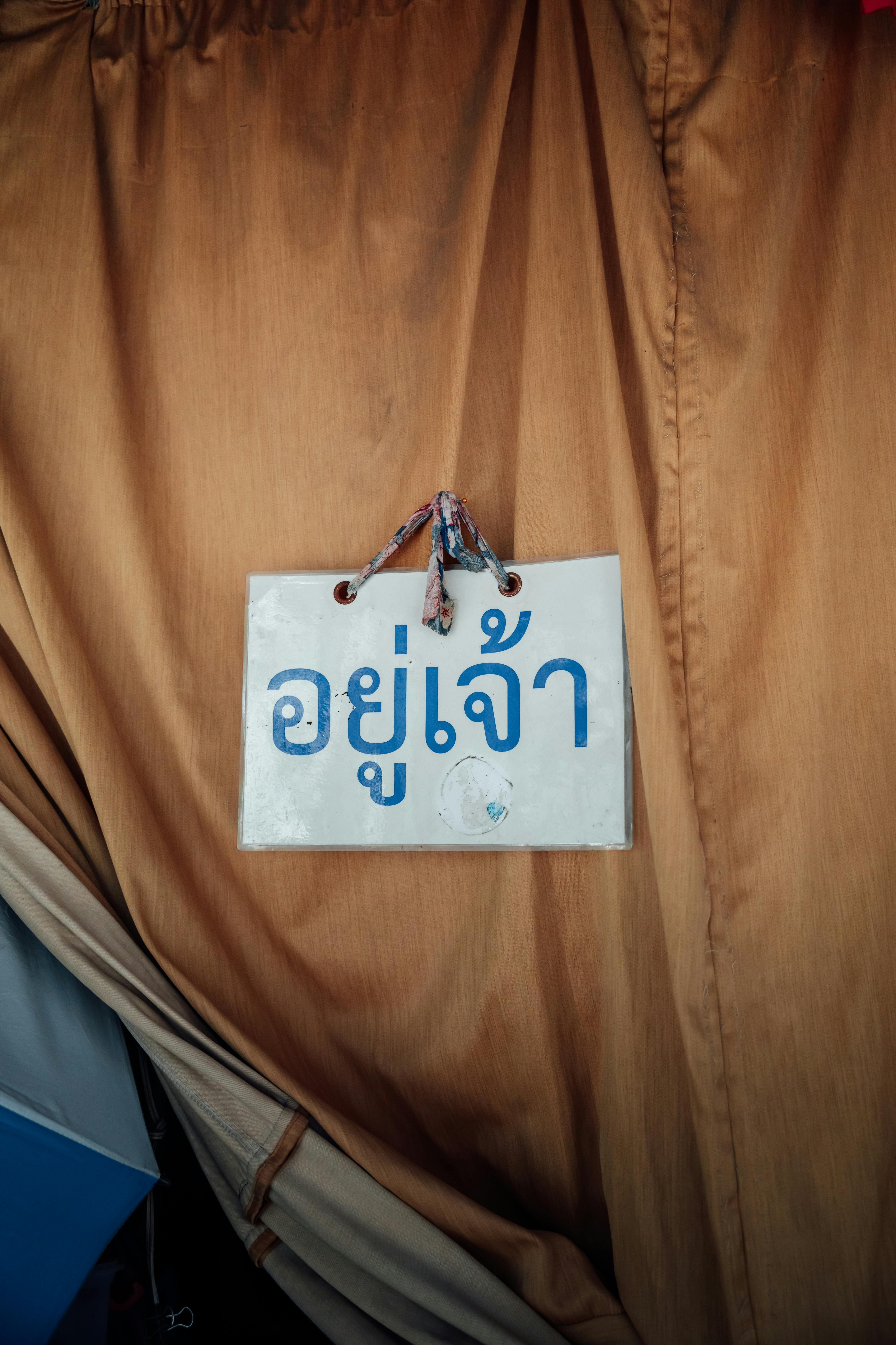 Thai Language Sign Hanging on Fabric · Free Stock Photo