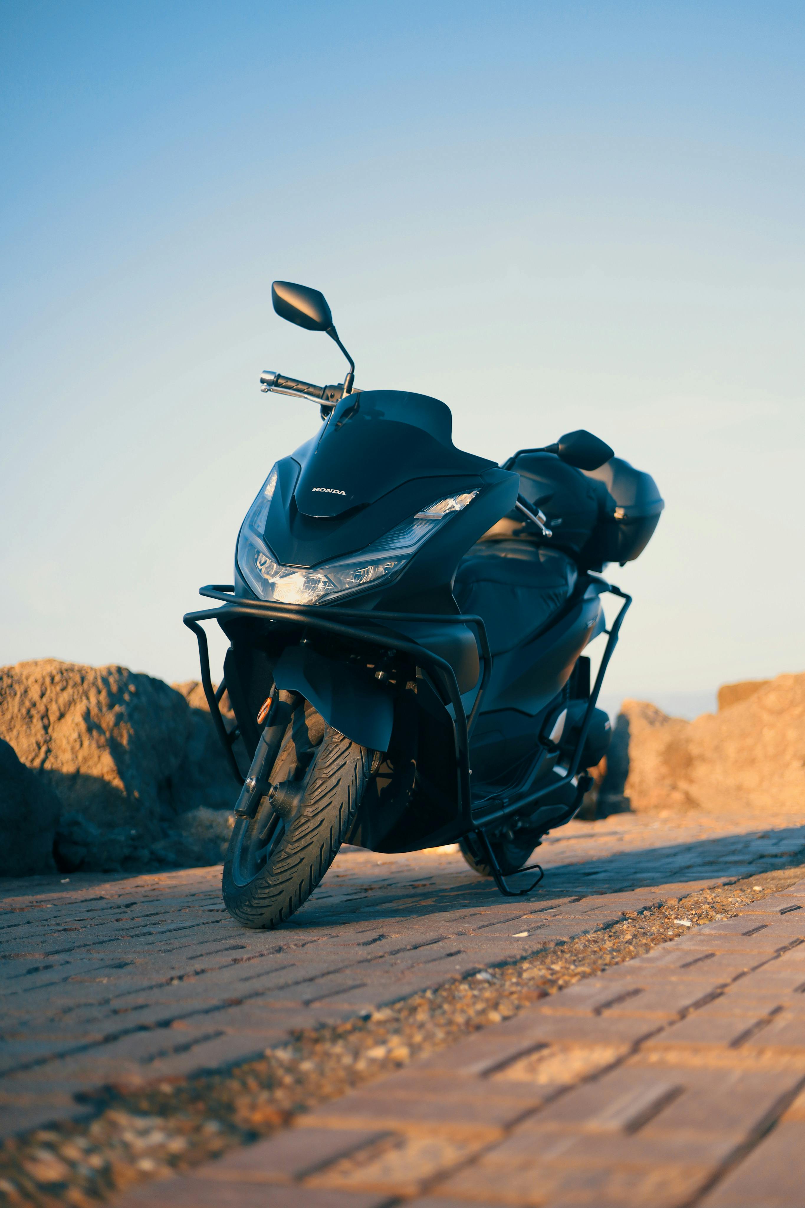 Sleek Black Motorcycle on Sunlit Path · Free Stock Photo