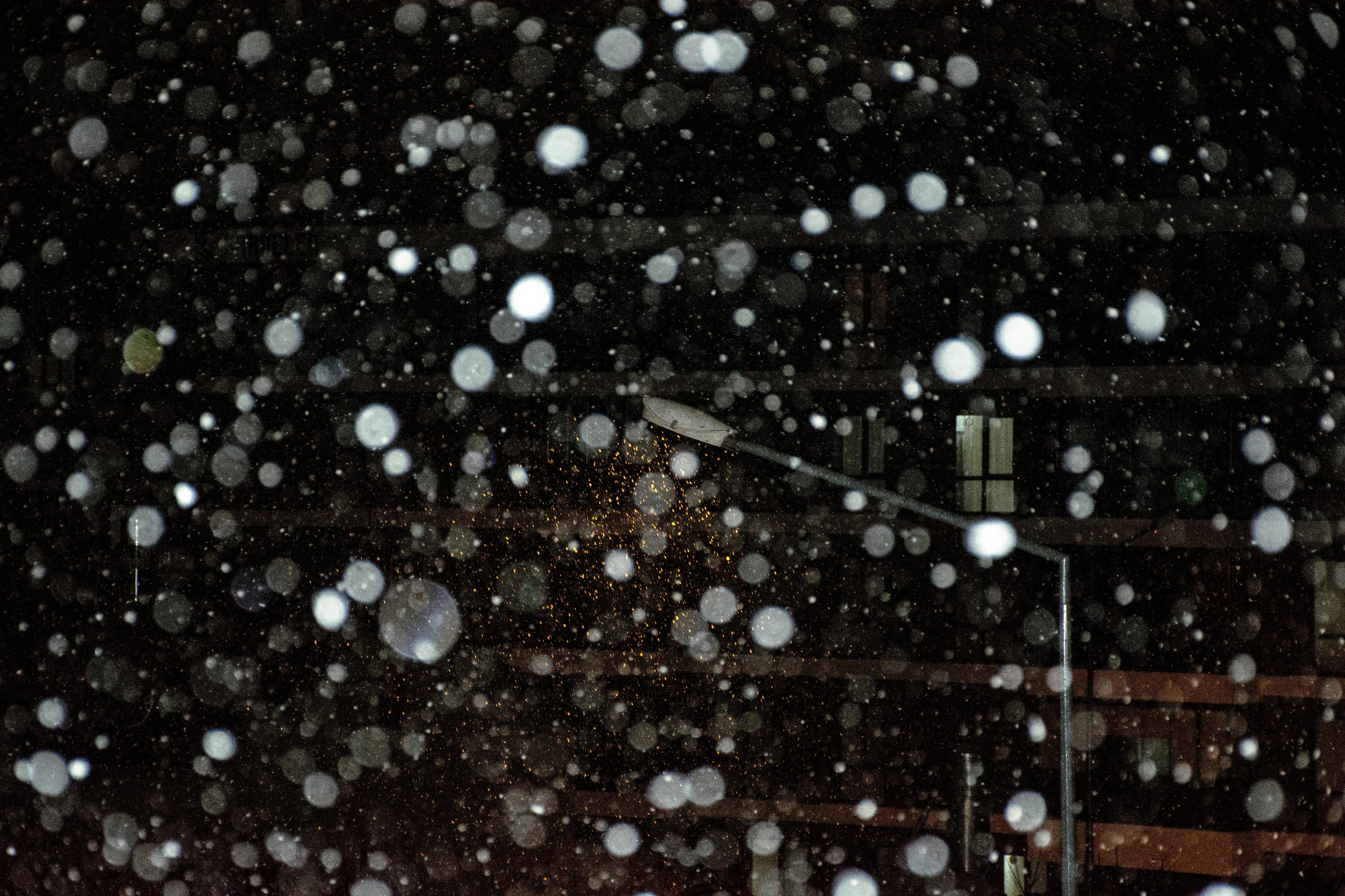 Snowfall at Night Urban Scene with Light Bokeh · Free Stock Photo