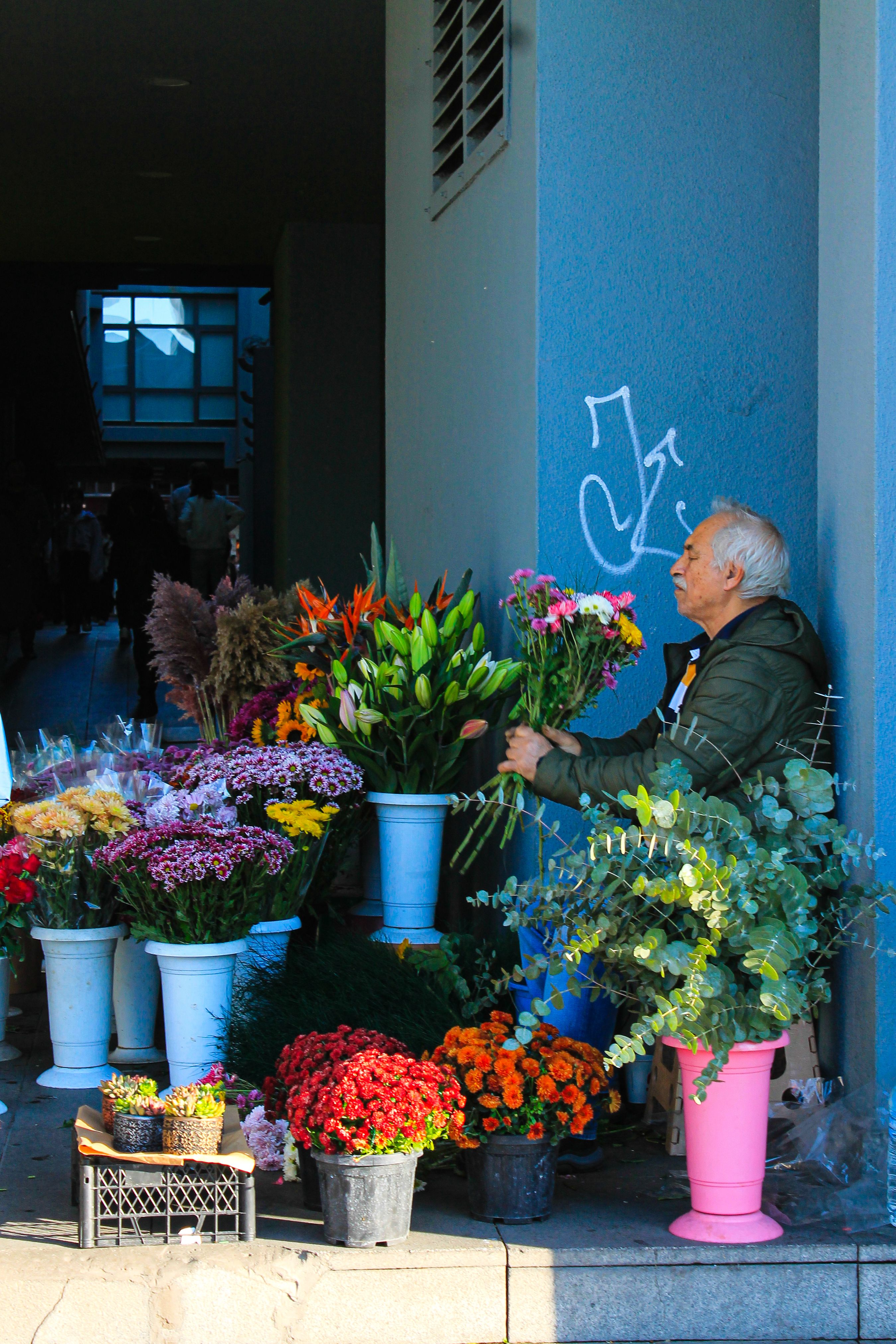 Colorful Outdoor Flower Stall with Vendor · Free Stock Photo