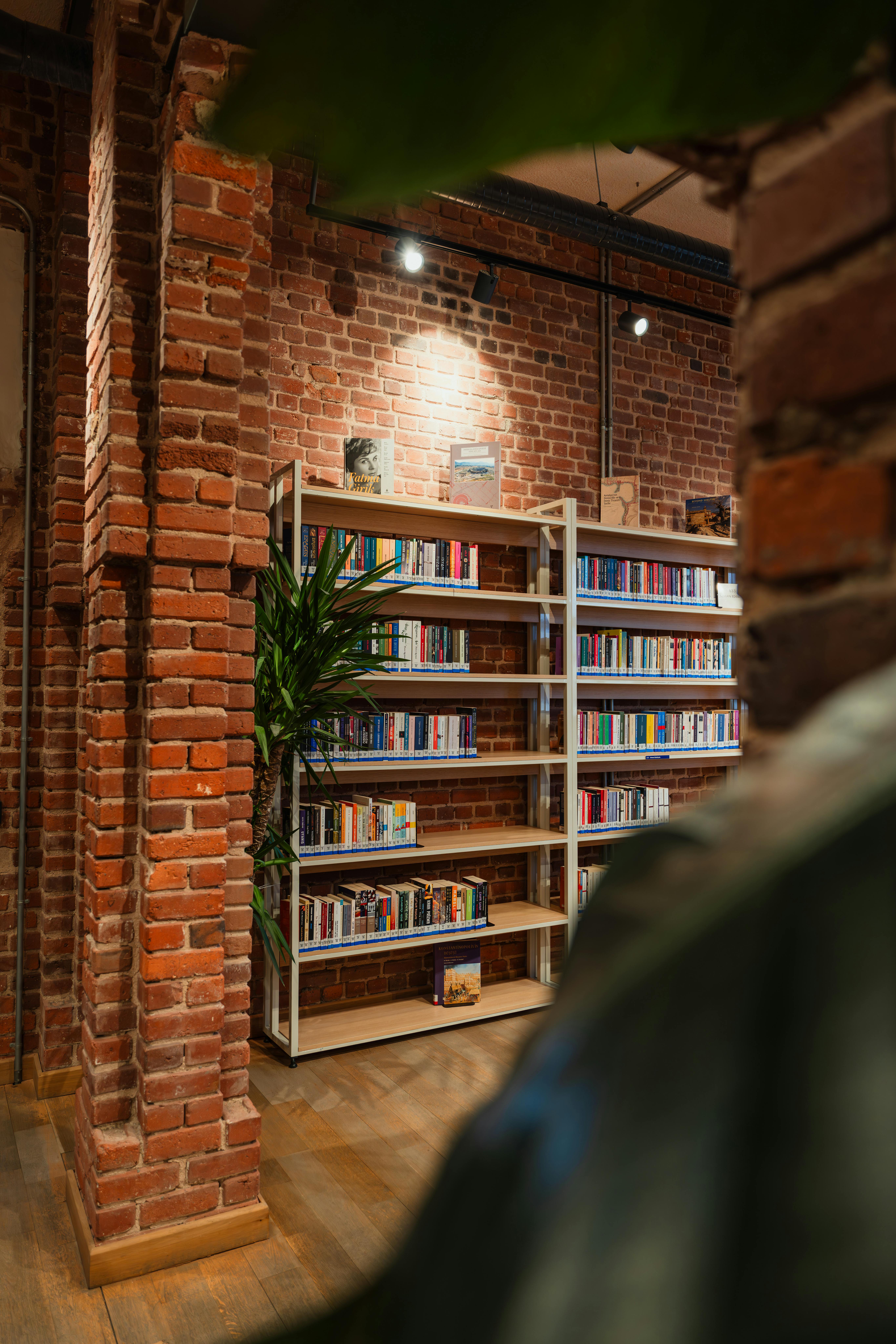 Cozy Brick-walled Library with Bookshelves · Free Stock Photo