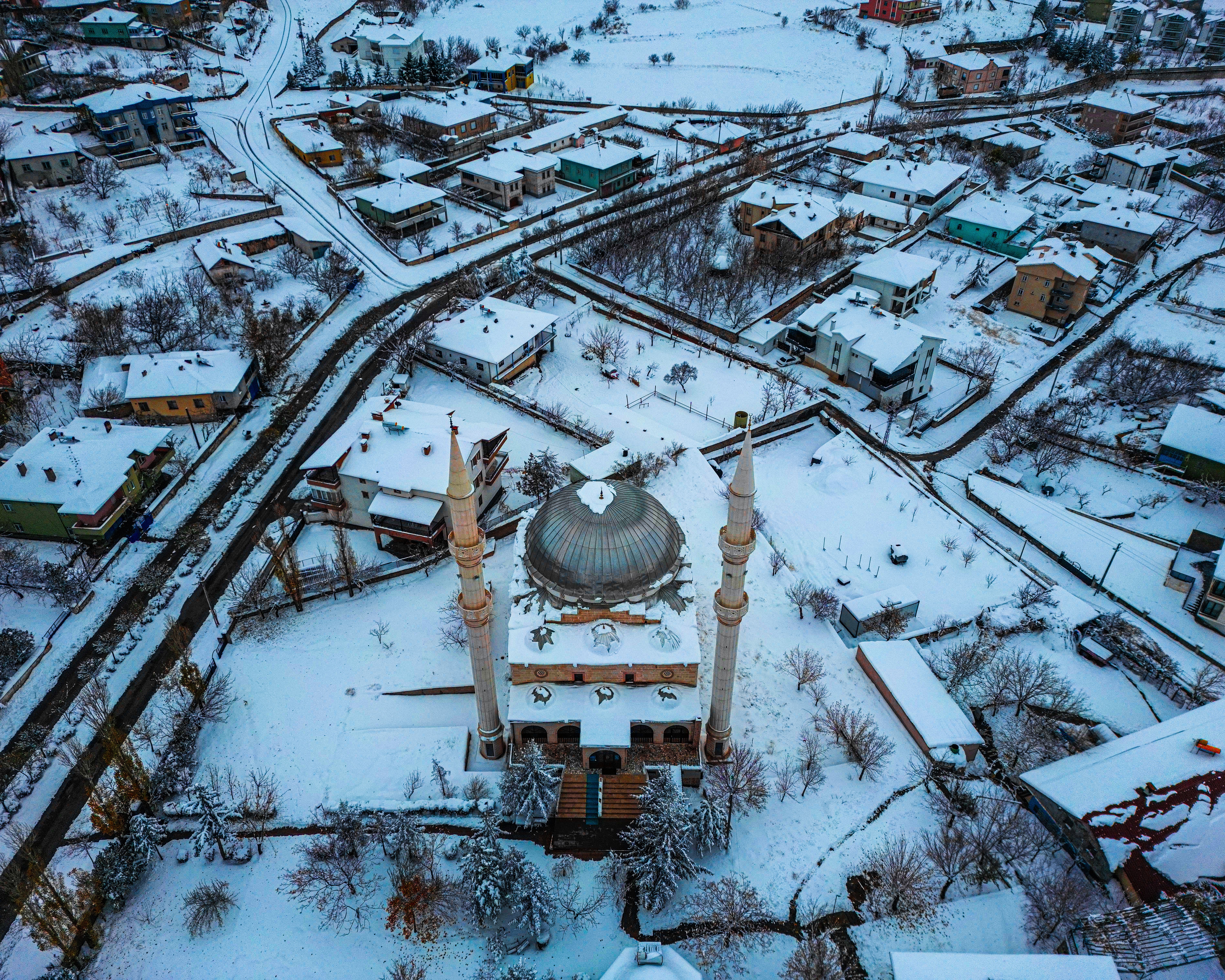 Aerial View of Snow-Covered Mosque in Winter Village · Free Stock Photo