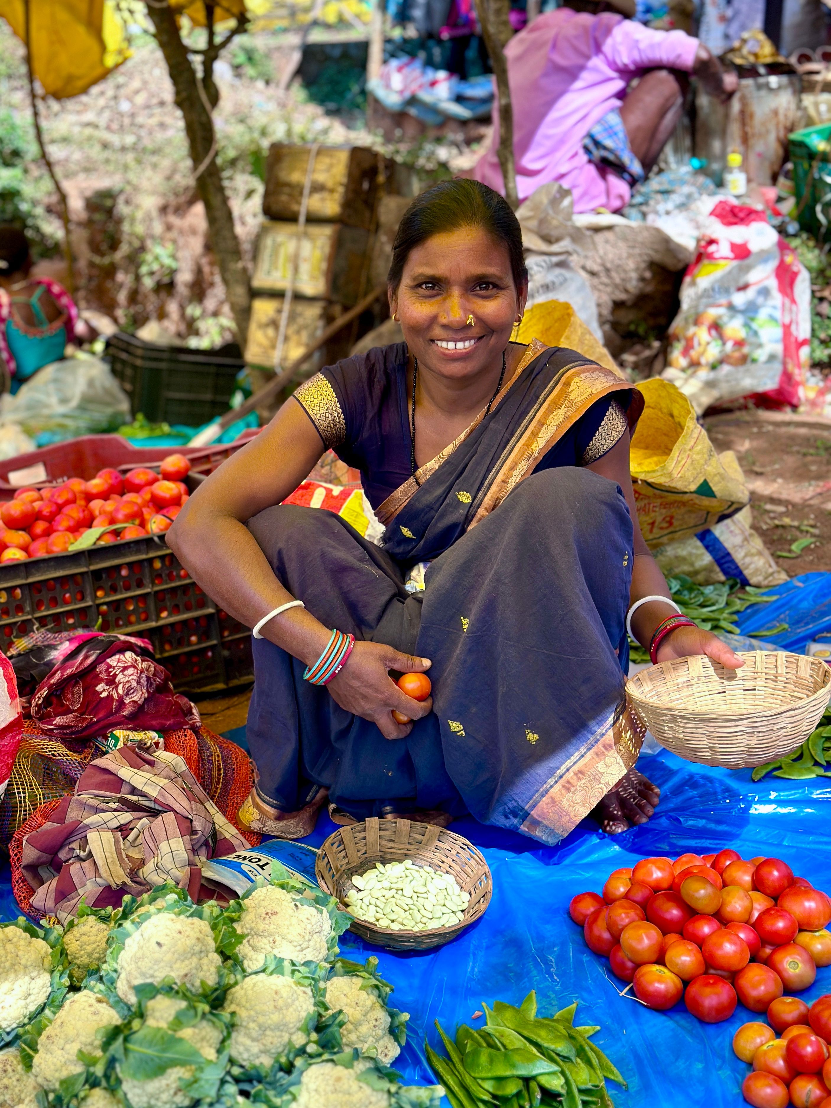 Smiling Woman at Vibrant Outdoor Market Stall · Free Stock Photo