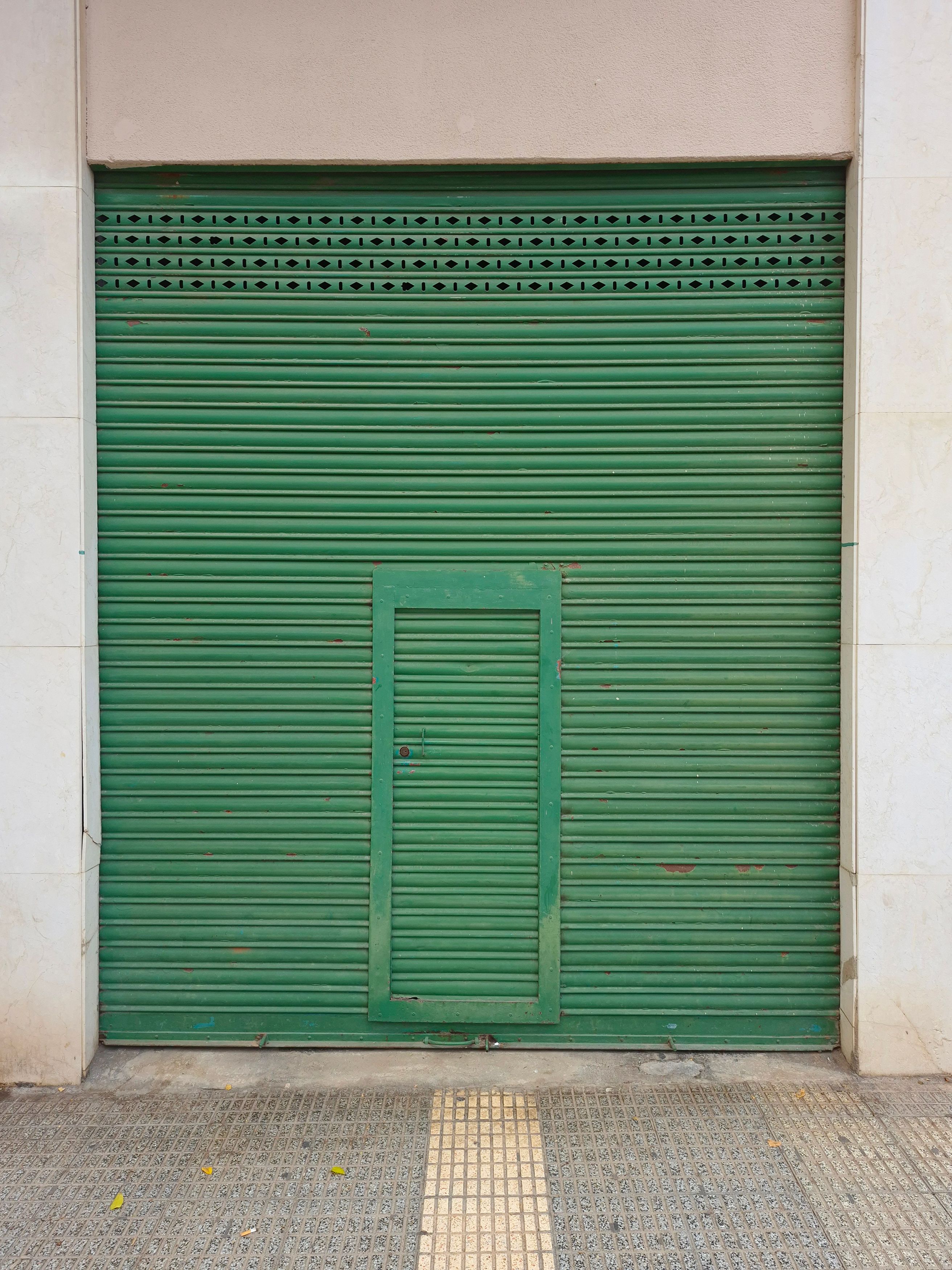 Green Security Shutter on Urban Storefront · Free Stock Photo