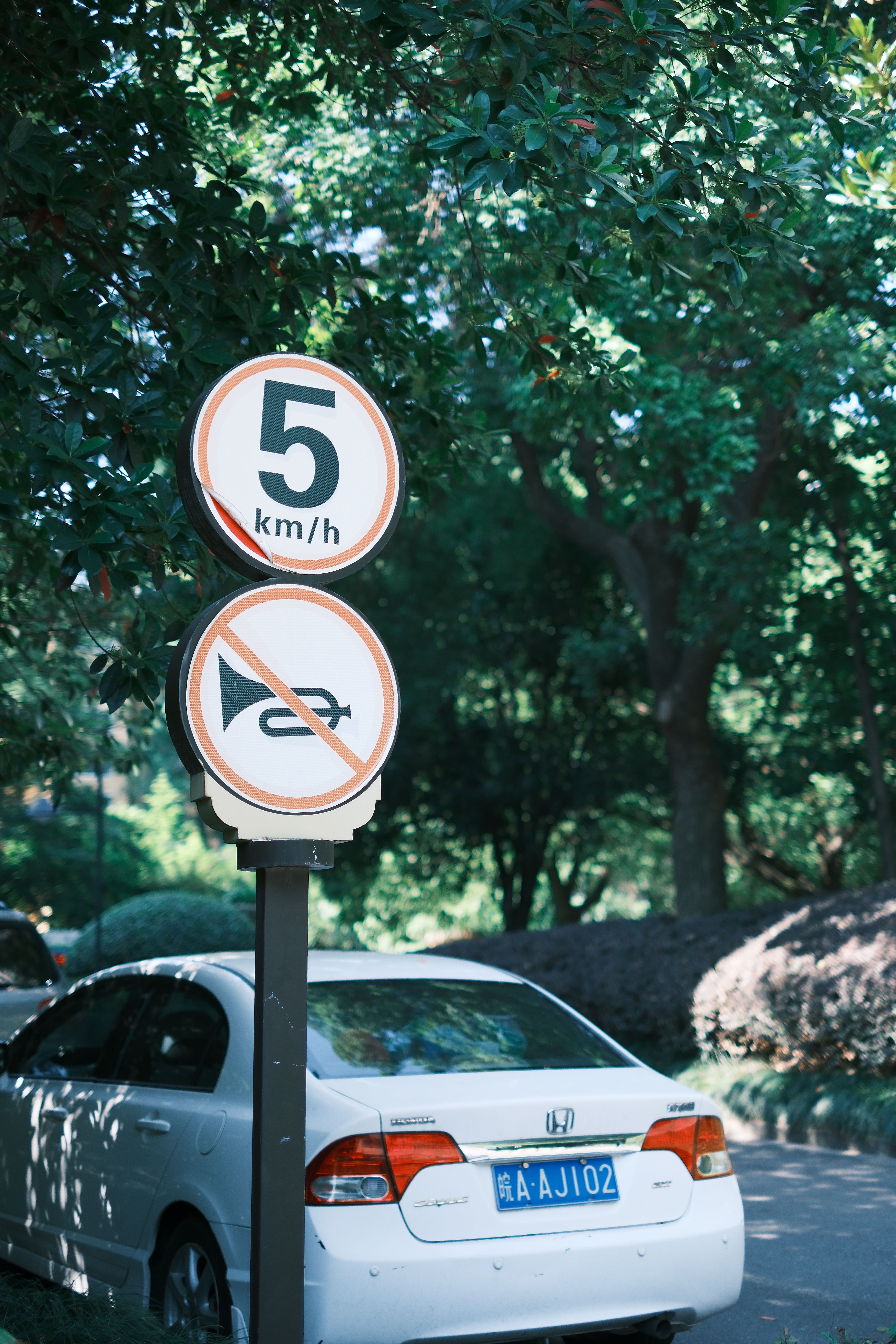 Traffic Sign and Car in Shaded Urban Area · Free Stock Photo