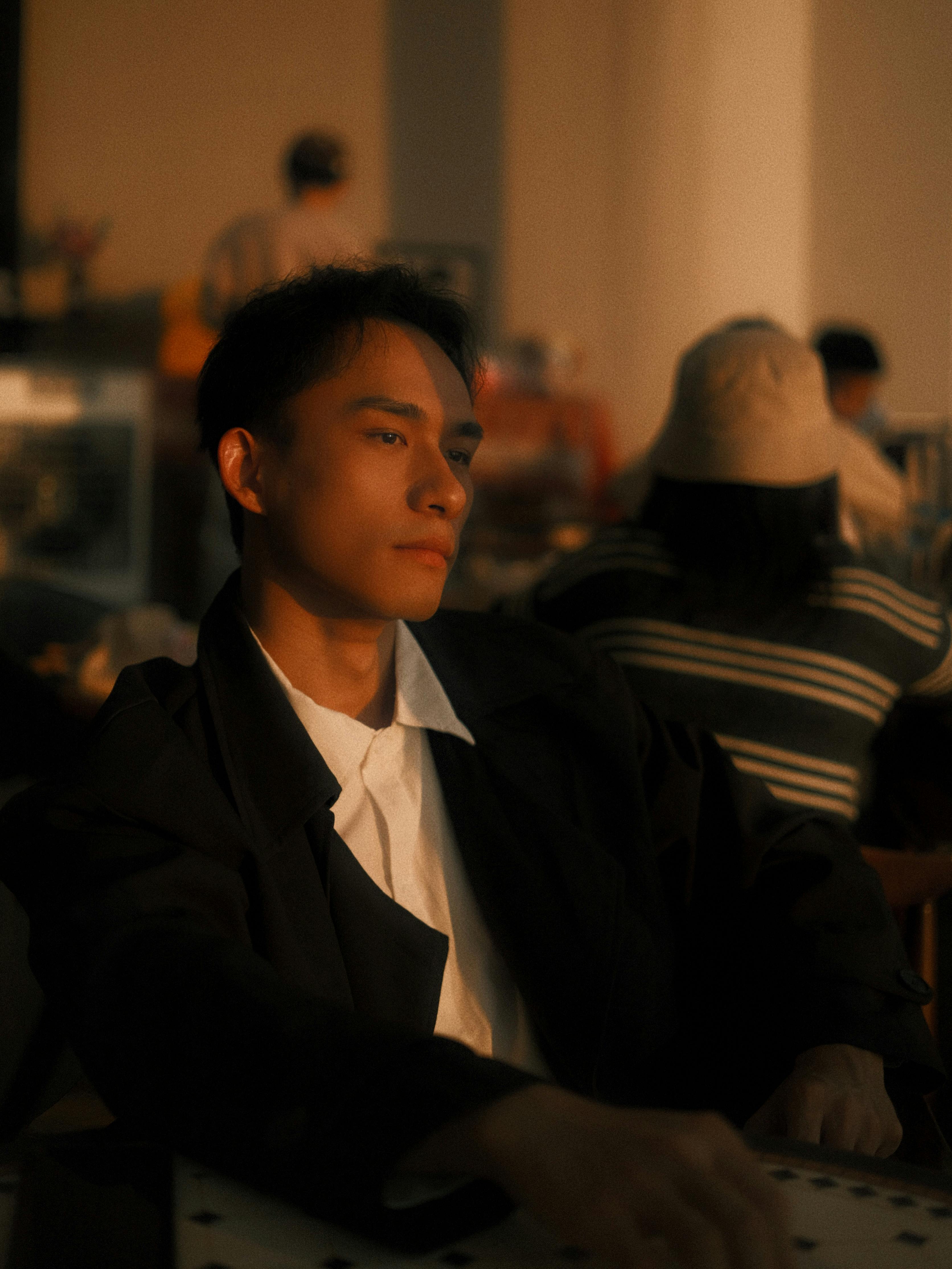 Moody Portrait of Young Man in Dim Cafe Lighting · Free Stock Photo