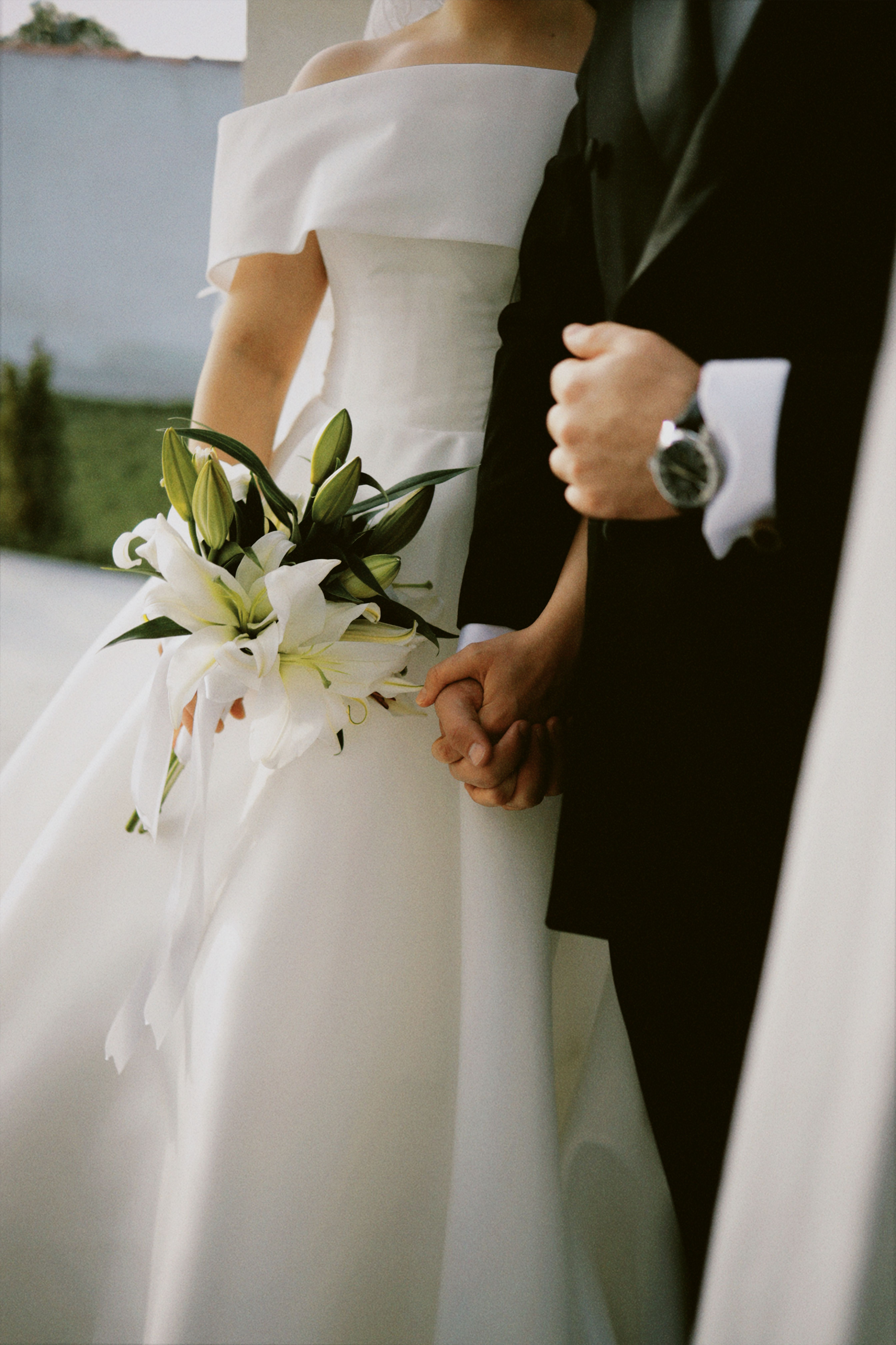 Elegant Wedding Couple Holding Hands with Lily Bouquet · Free Stock Photo