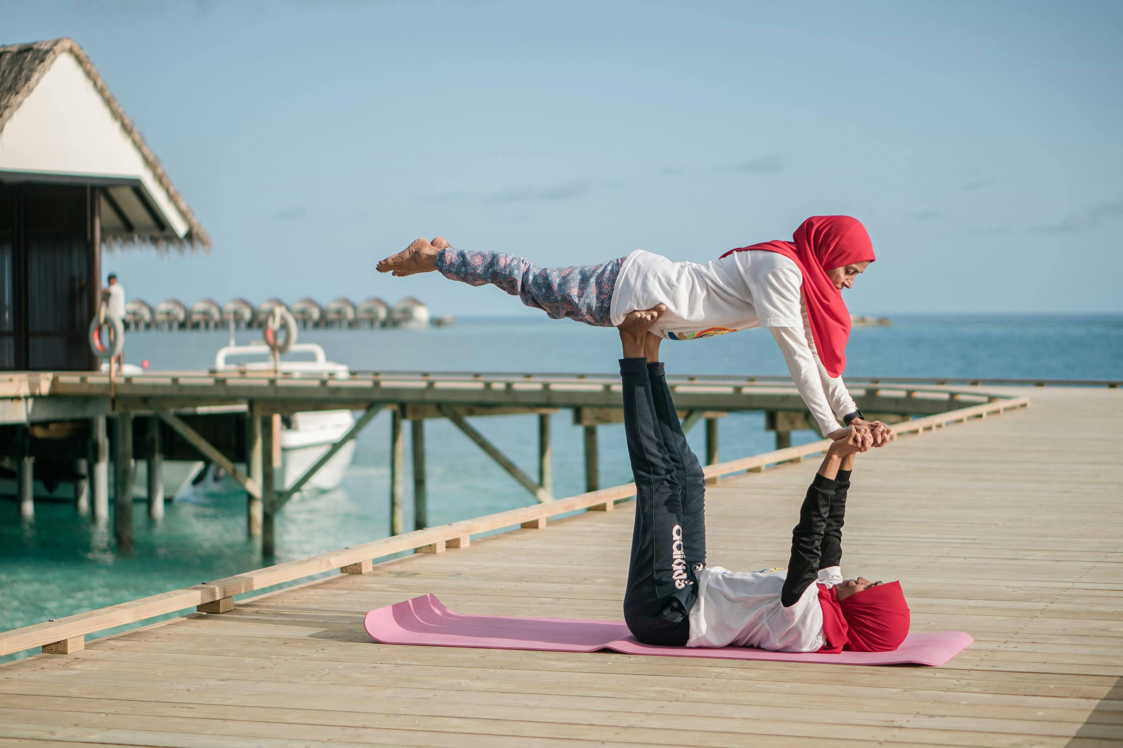 Couple Performing Acro Yoga on Scenic Deck · Free Stock Photo