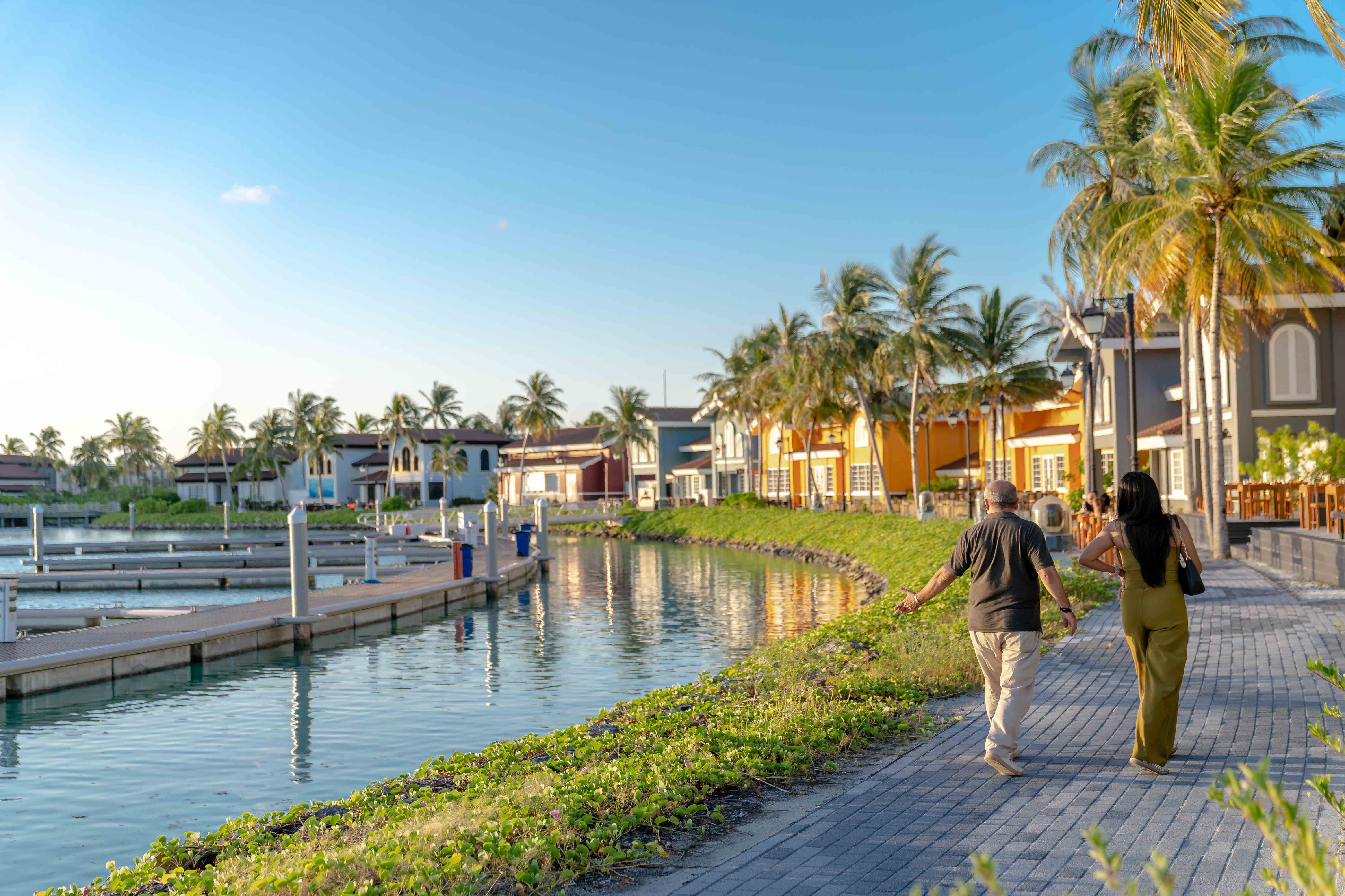 Couple Strolling Along Scenic Marina Pathway · Free Stock Photo