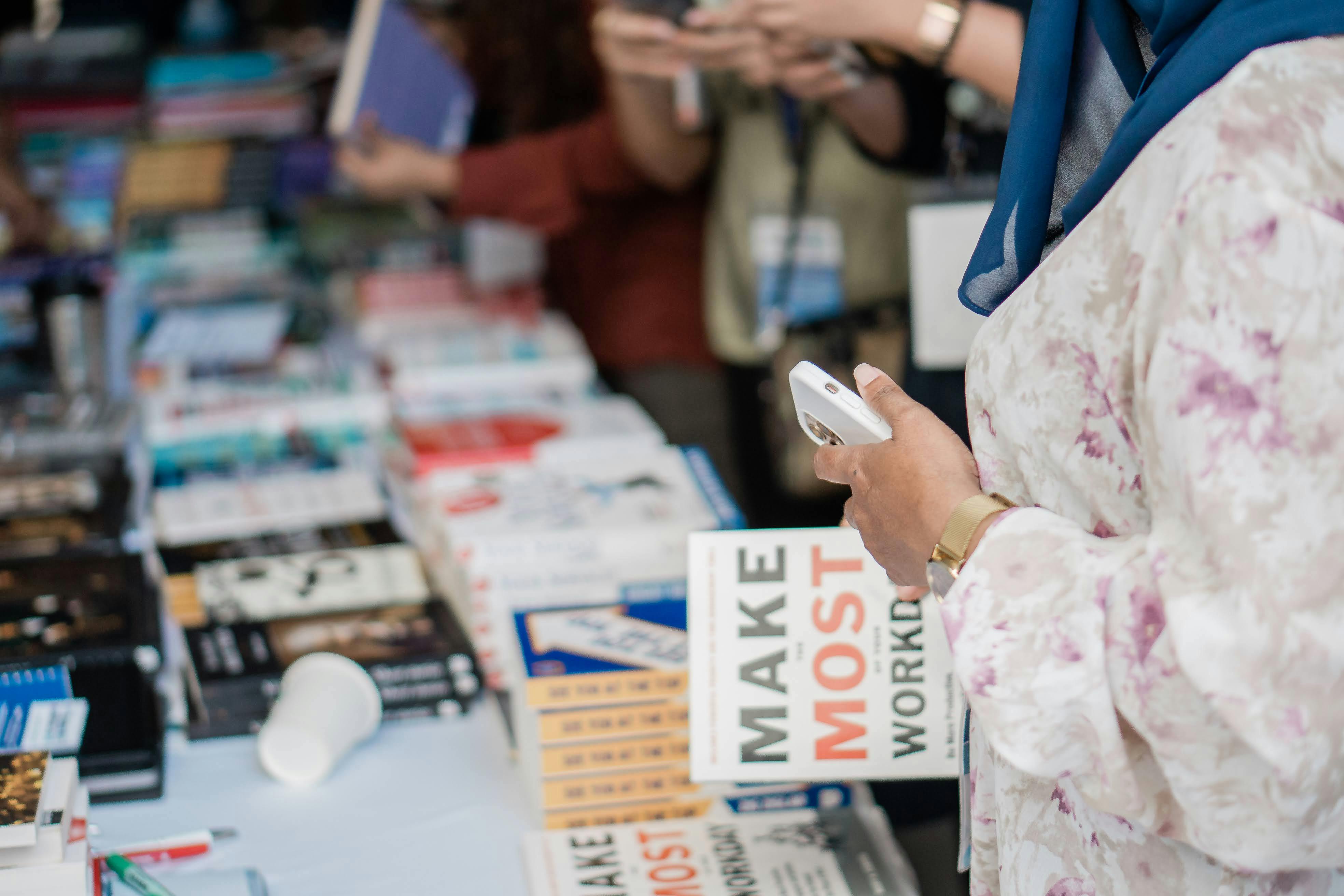 Book Fair Table Display with Books and People · Free Stock Photo