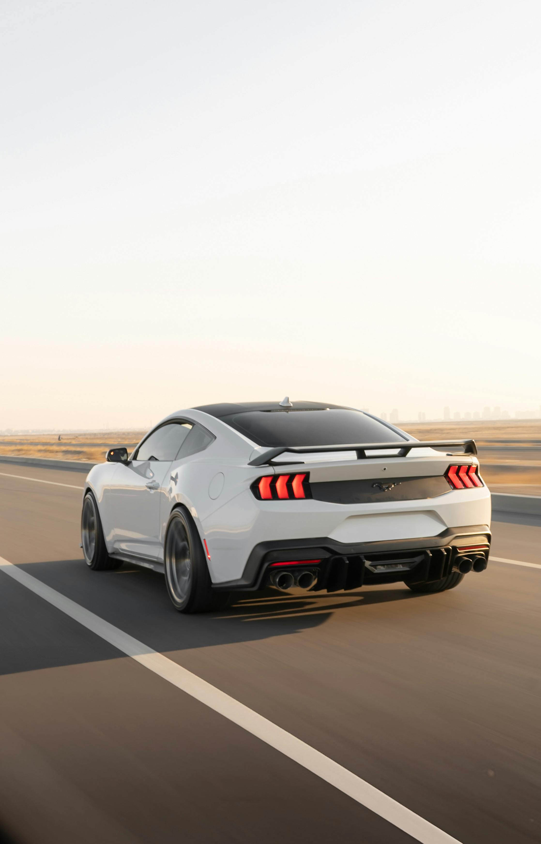 Sleek White Mustang Driving on Open Road · Free Stock Photo