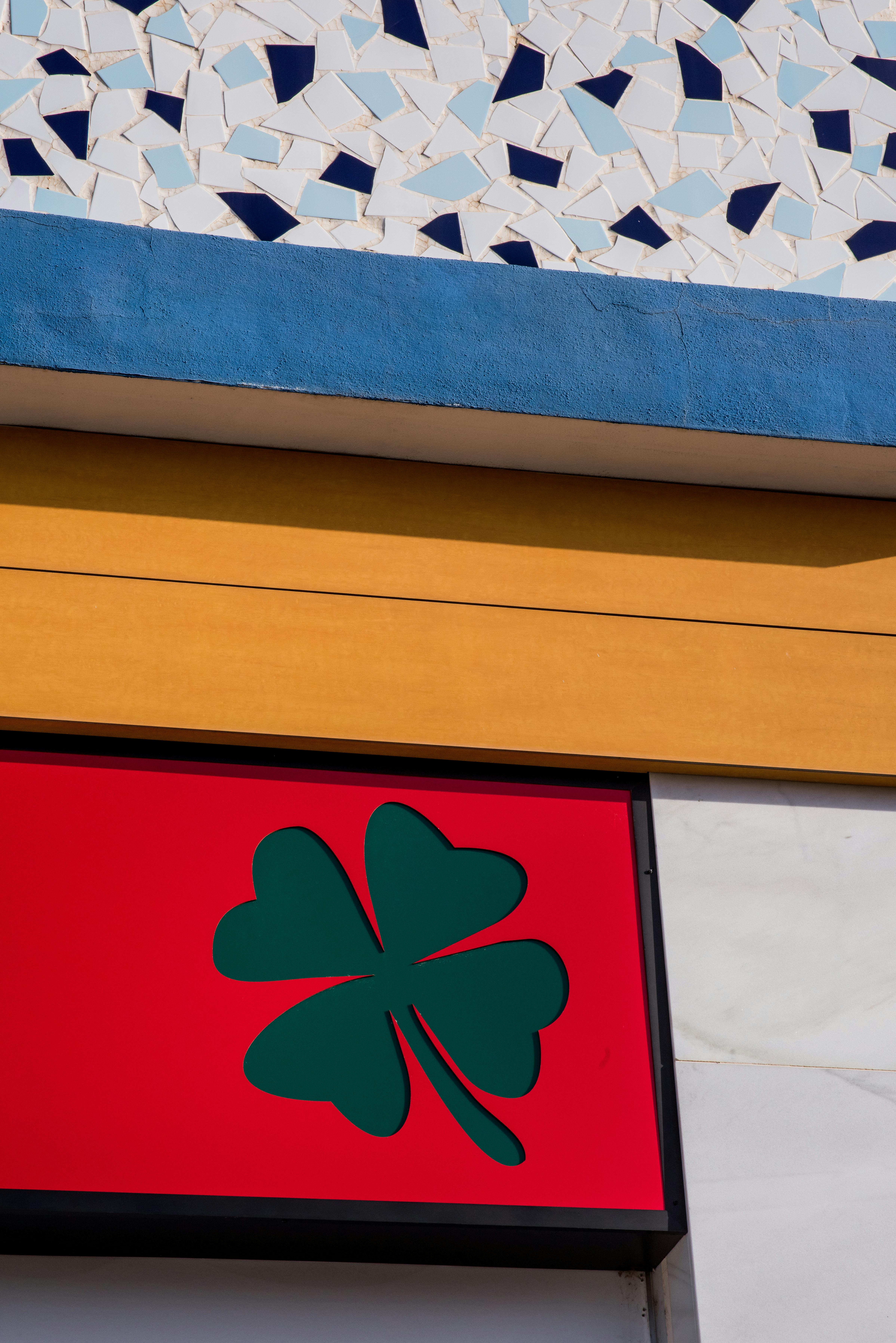 Four Leaf Clover Sign on Mosaic Wall Exterior · Free Stock Photo