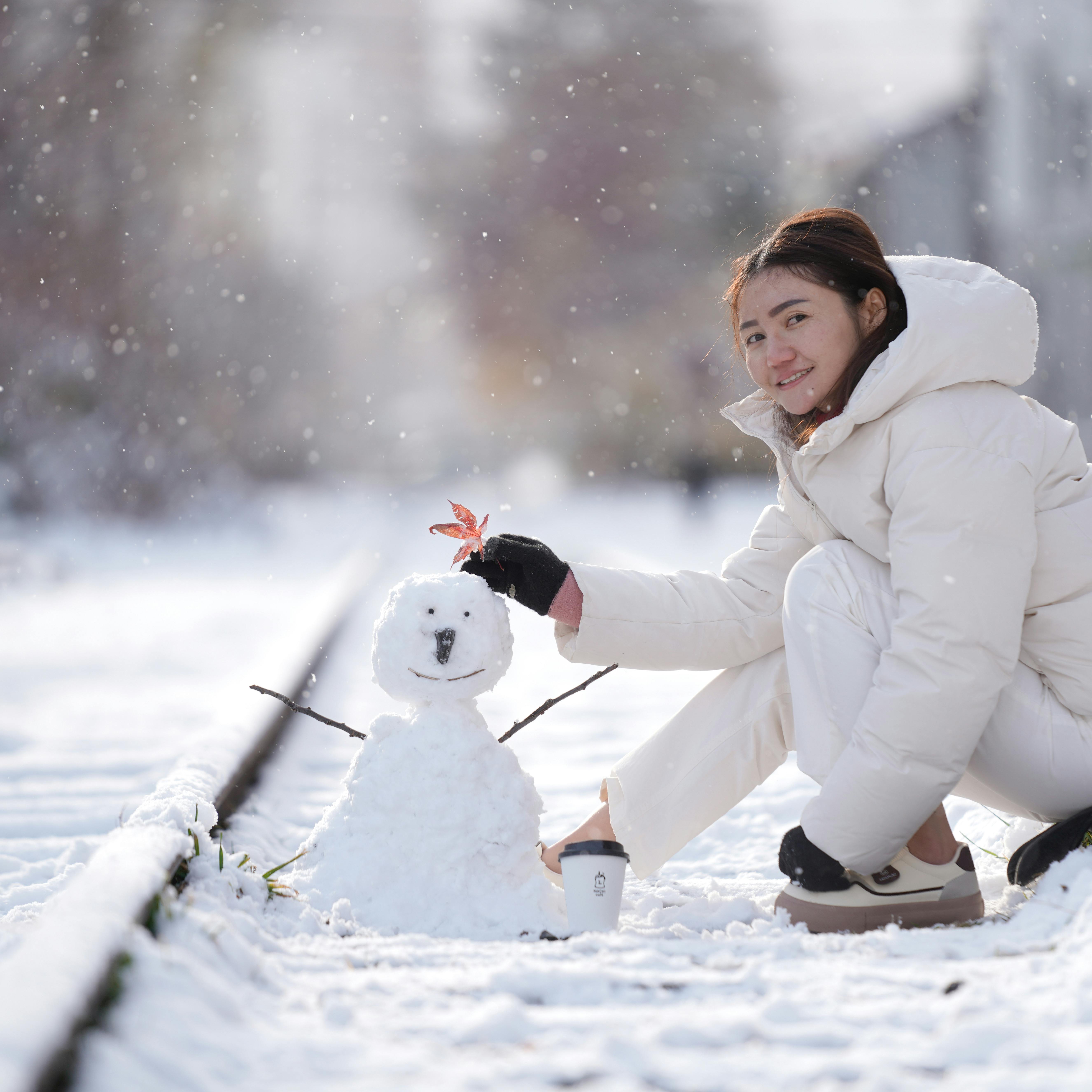 Woman Enjoying Winter Day with Snowman · Free Stock Photo