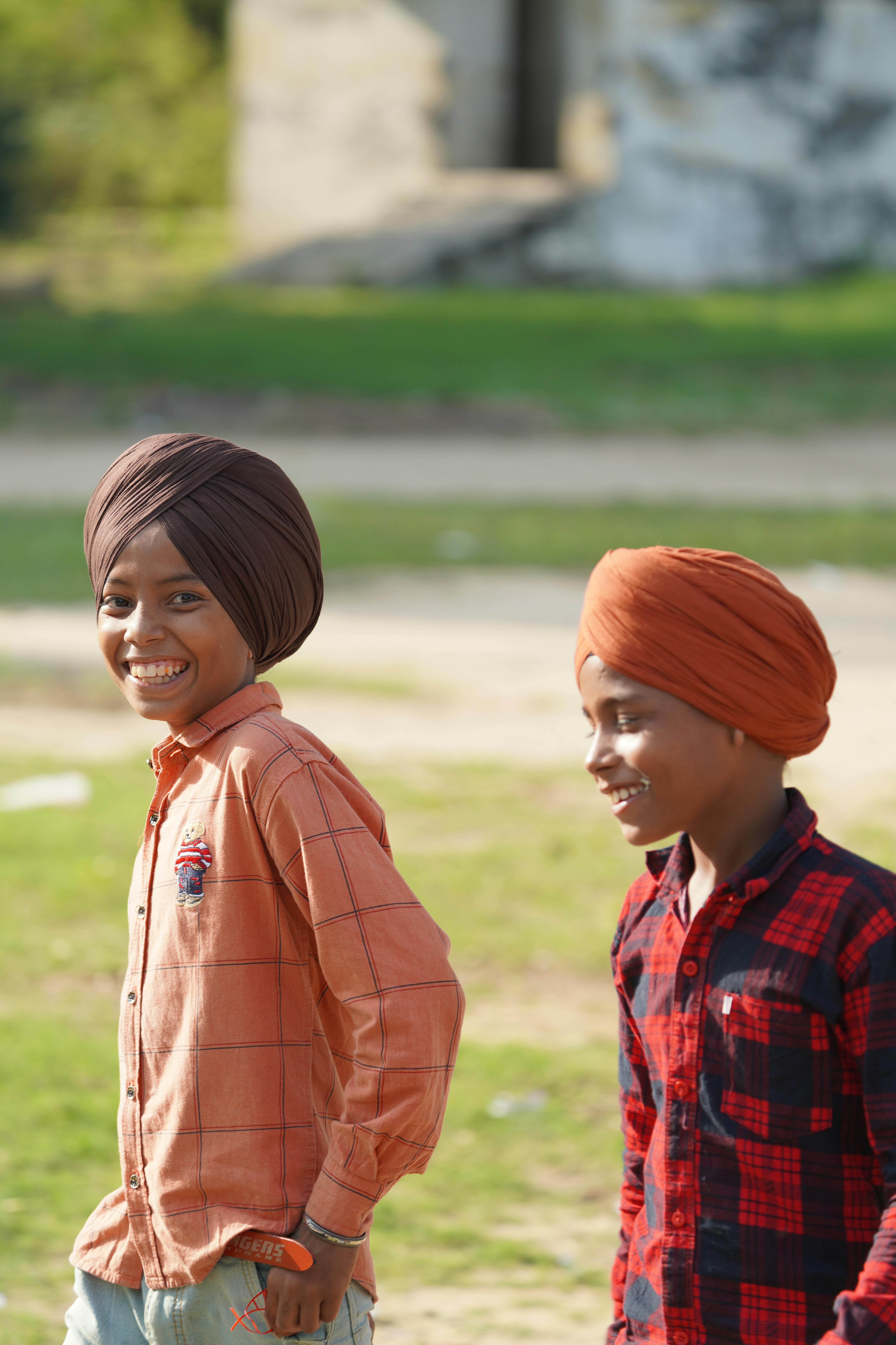 Two Smiling Boys Outdoors in Colorful Turbans · Free Stock Photo