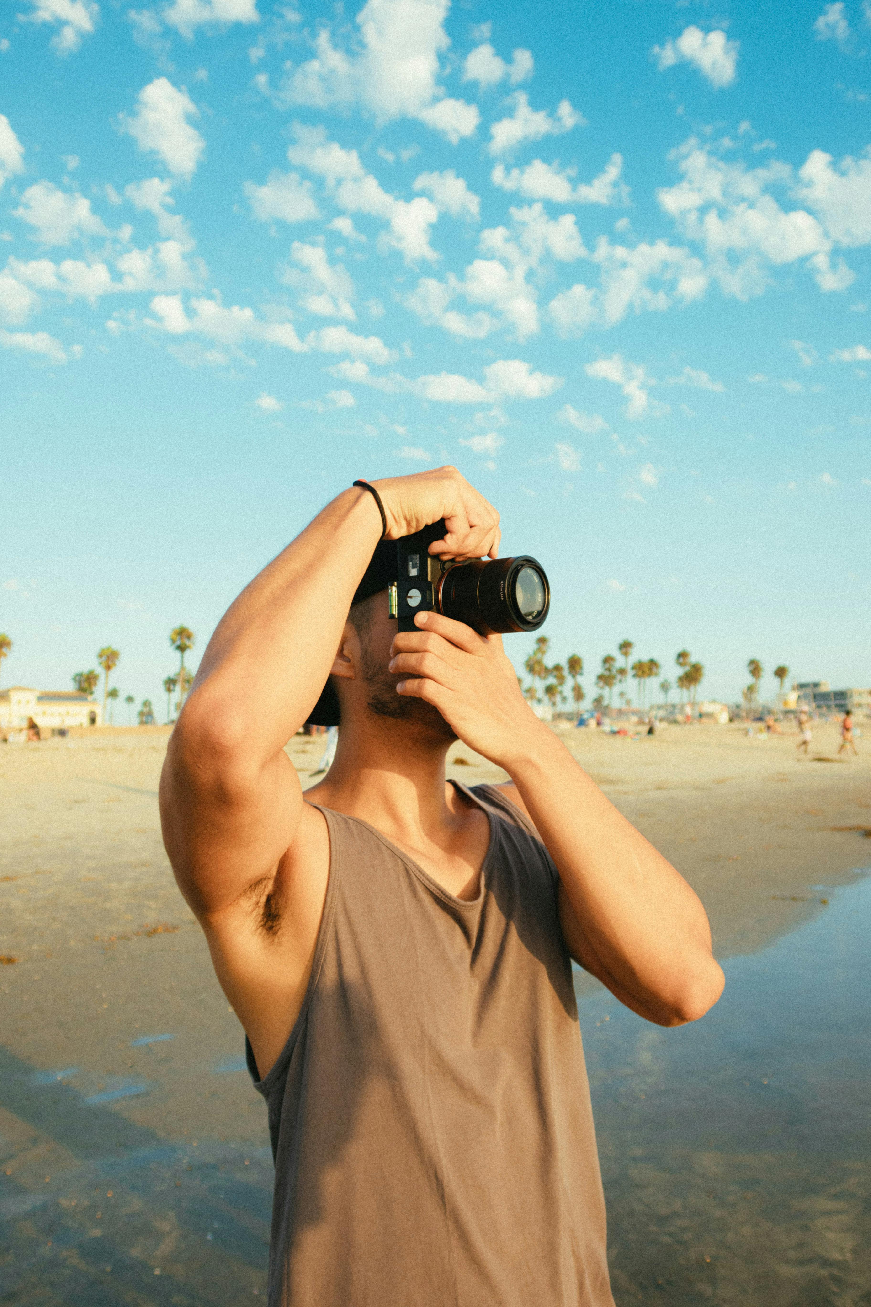 Man Using Dslr Camera While Standing on Seashore · Free Stock Photo