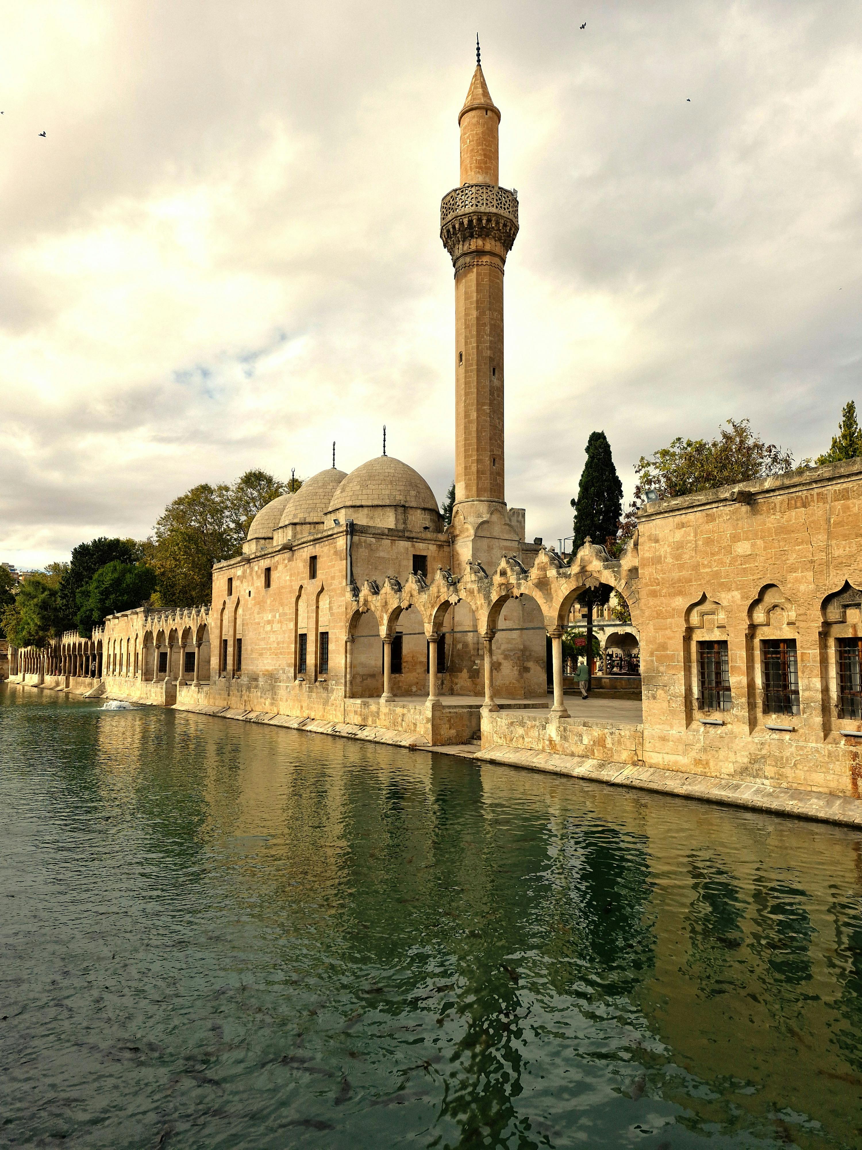 Historic Mosque by Tranquil River in Autumn · Free Stock Photo