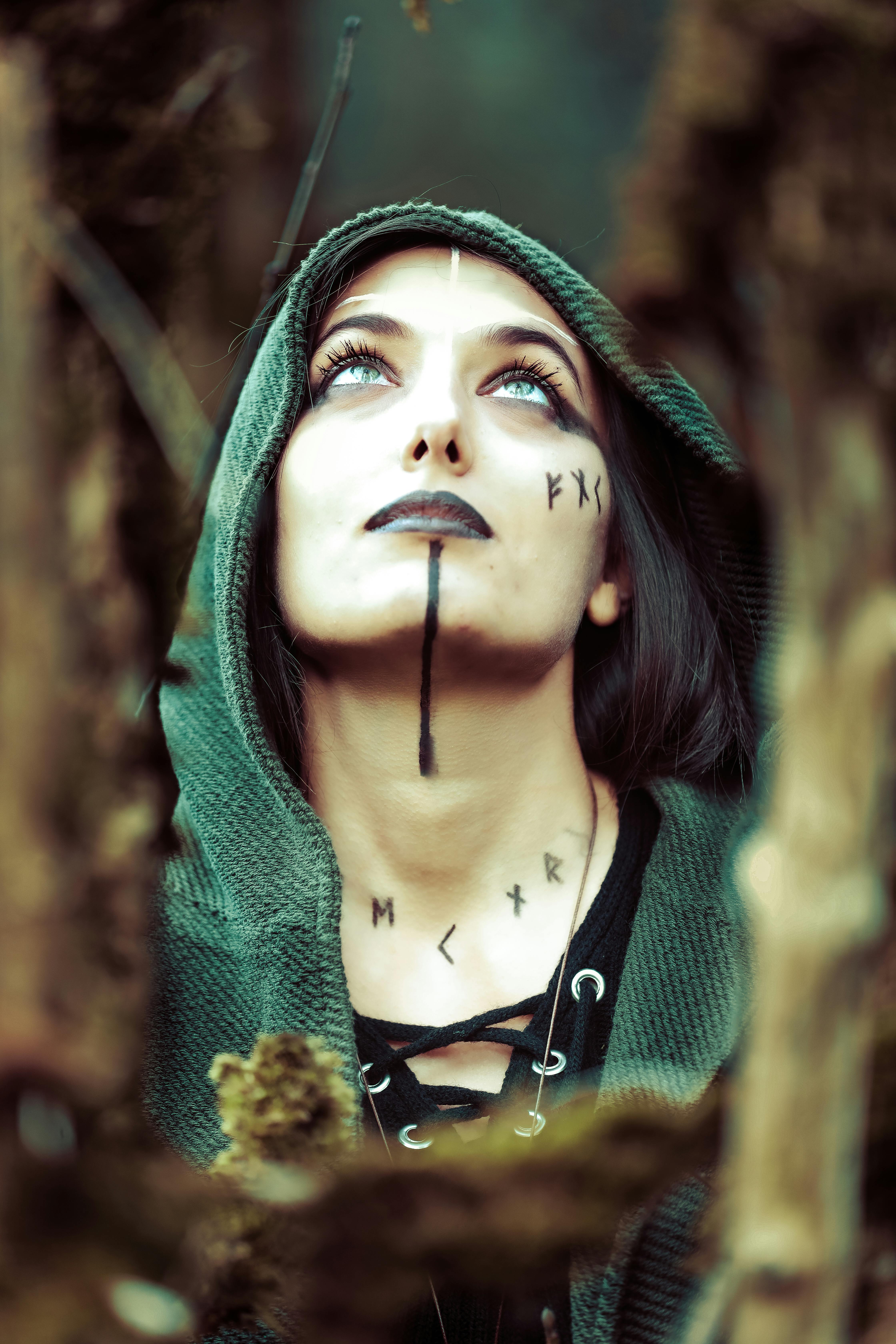 Mystical Woman in Green Hood with Rune Symbols · Free Stock Photo