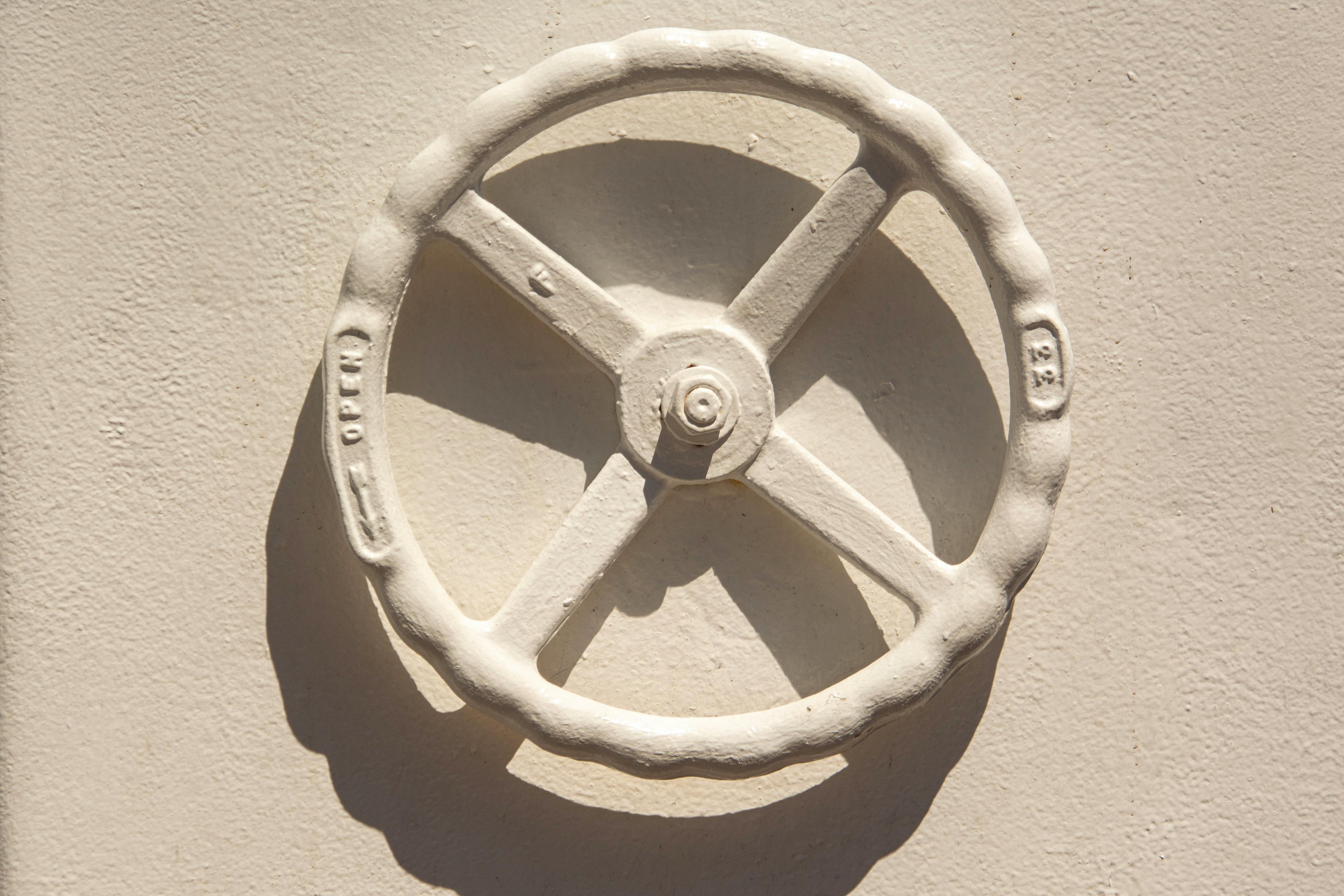 Industrial Wheel Shadow on Textured Wall · Free Stock Photo