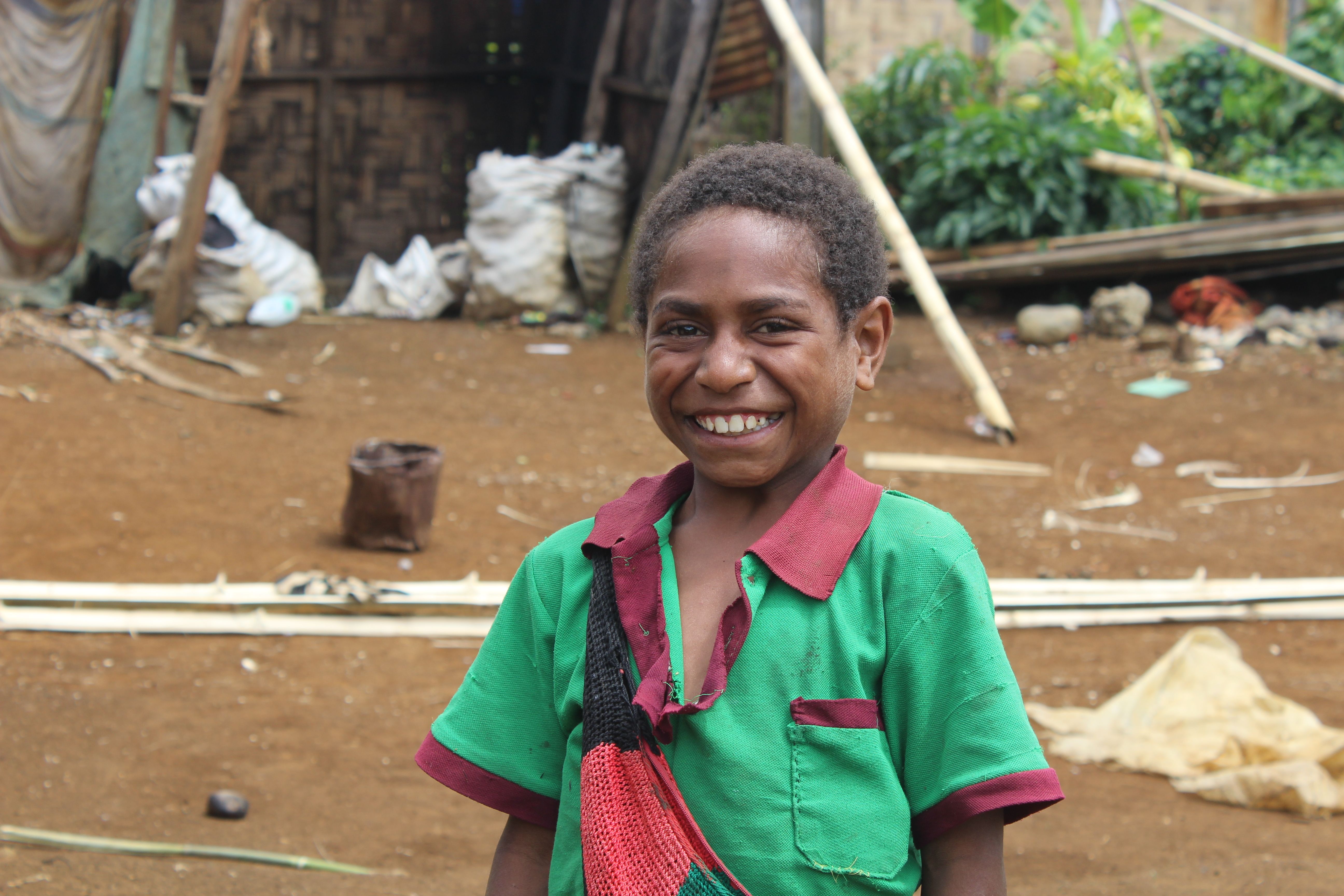 Smiling Child in Rural Setting Wearing Green Shirt · Free Stock Photo