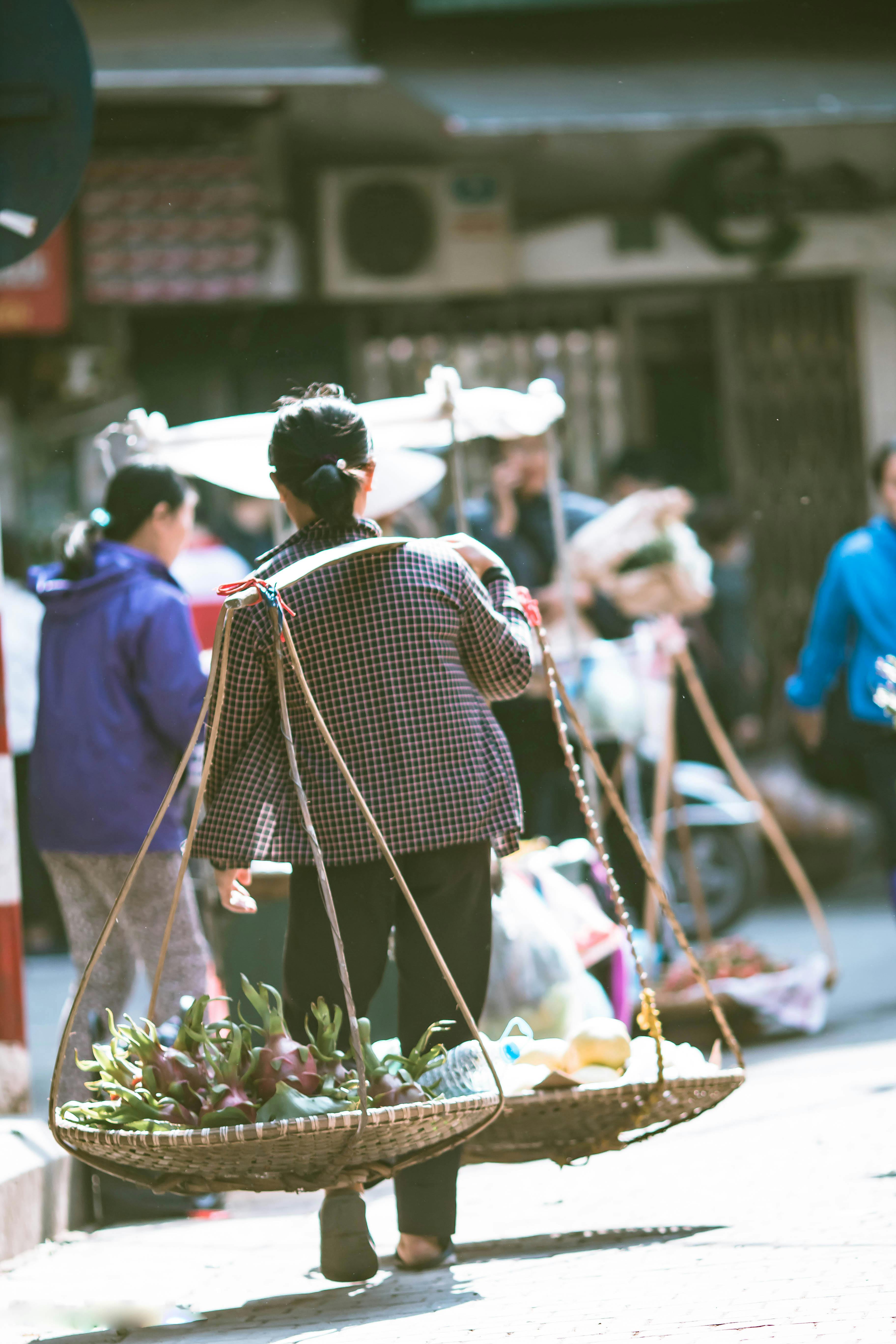 Traditional Street Vendor in Hanoi's Bustling Market · Free Stock Photo
