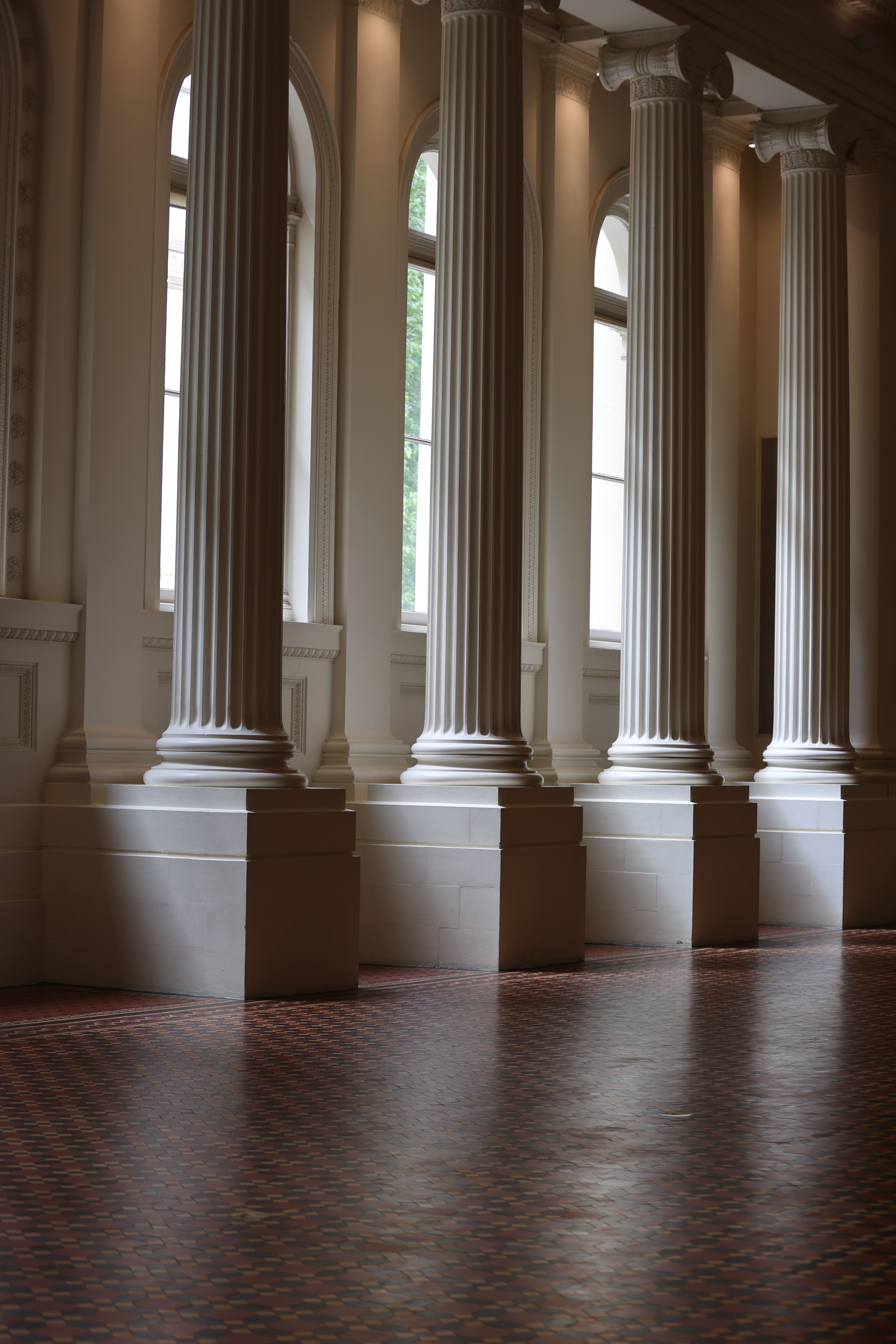 Elegant Classical Columns in Sunlit Hallway · Free Stock Photo