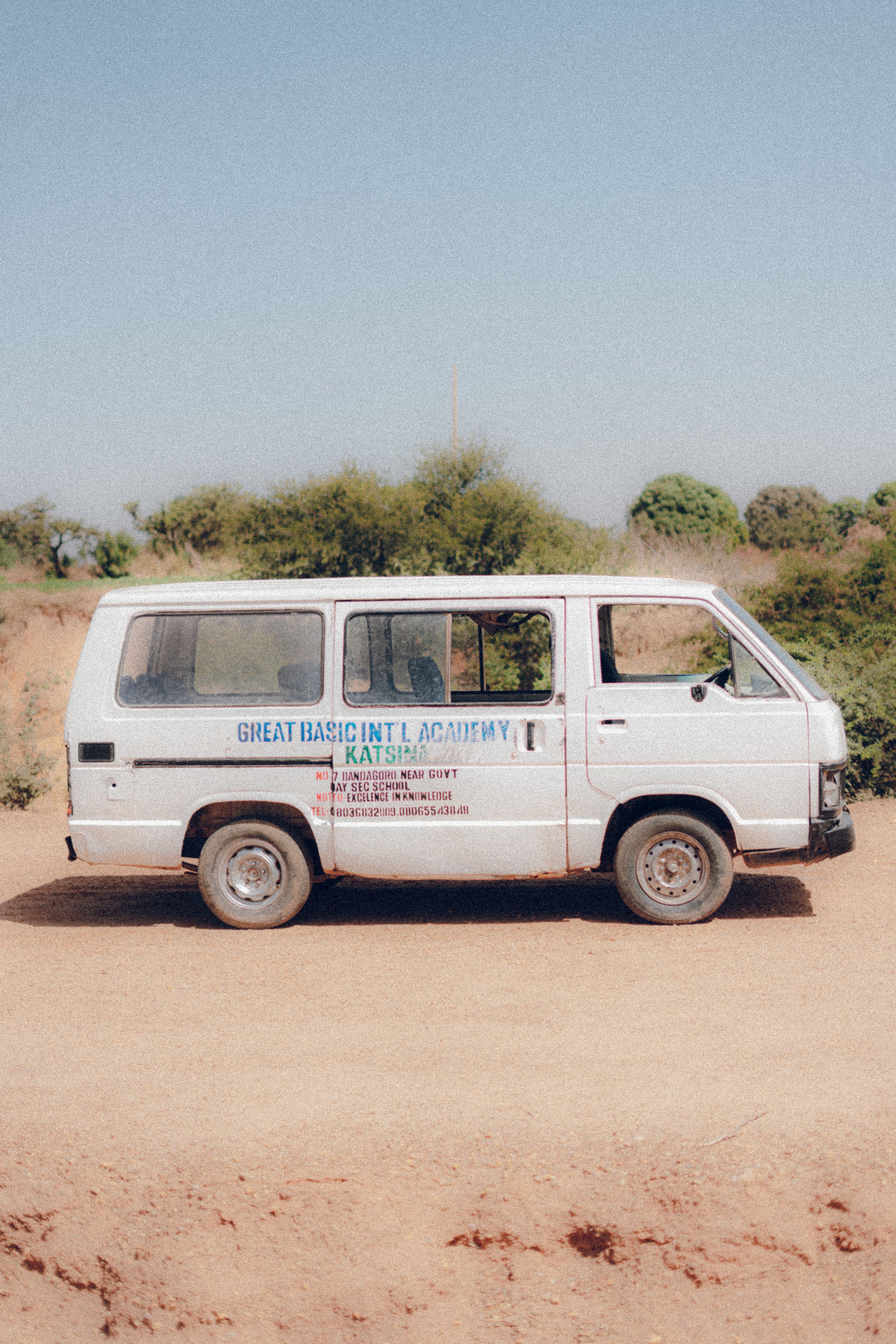 White Minibus on Dusty Road in Nigeria · Free Stock Photo