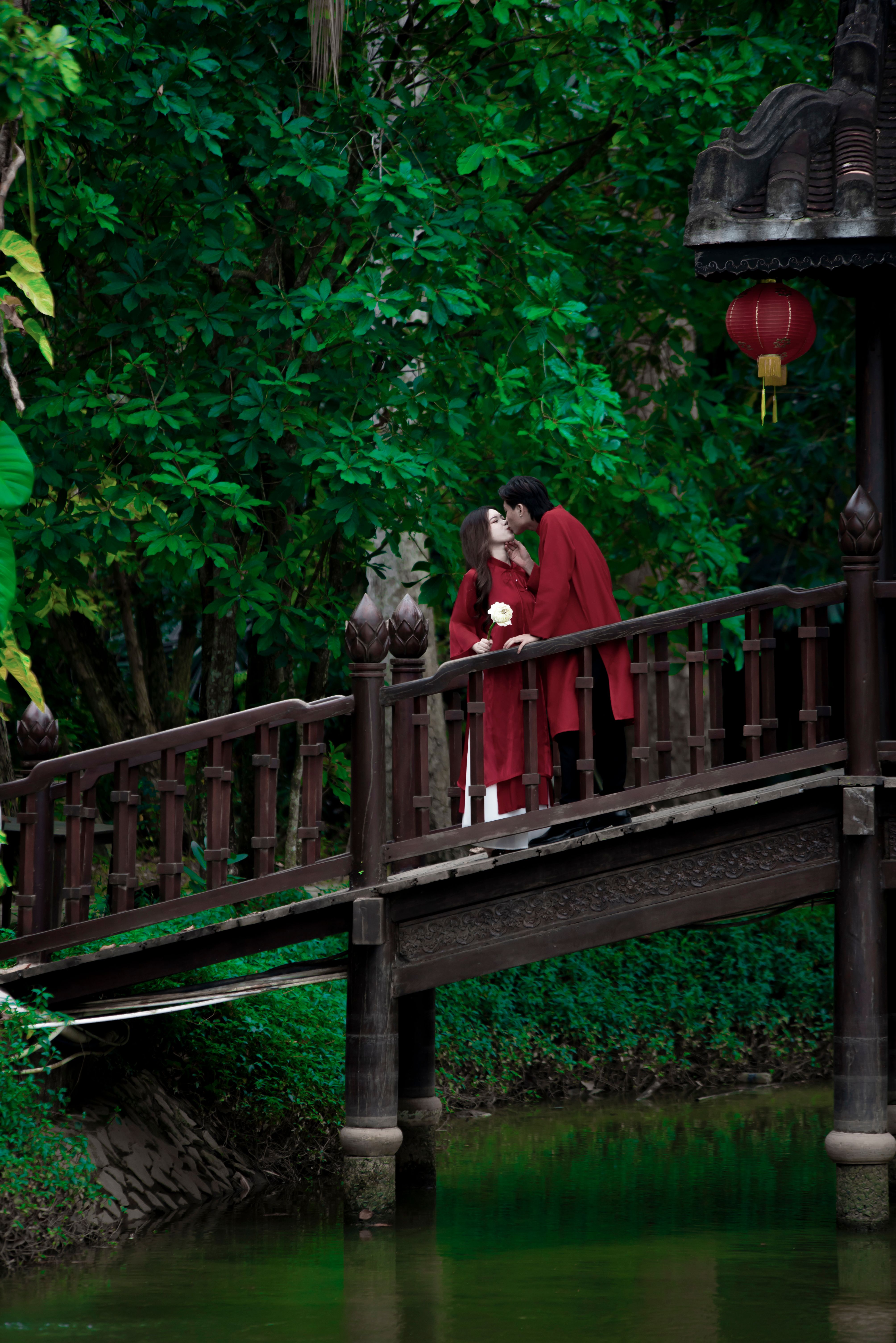 Romantic Couple on Rustic Bridge in Lush Forest · Free Stock Photo