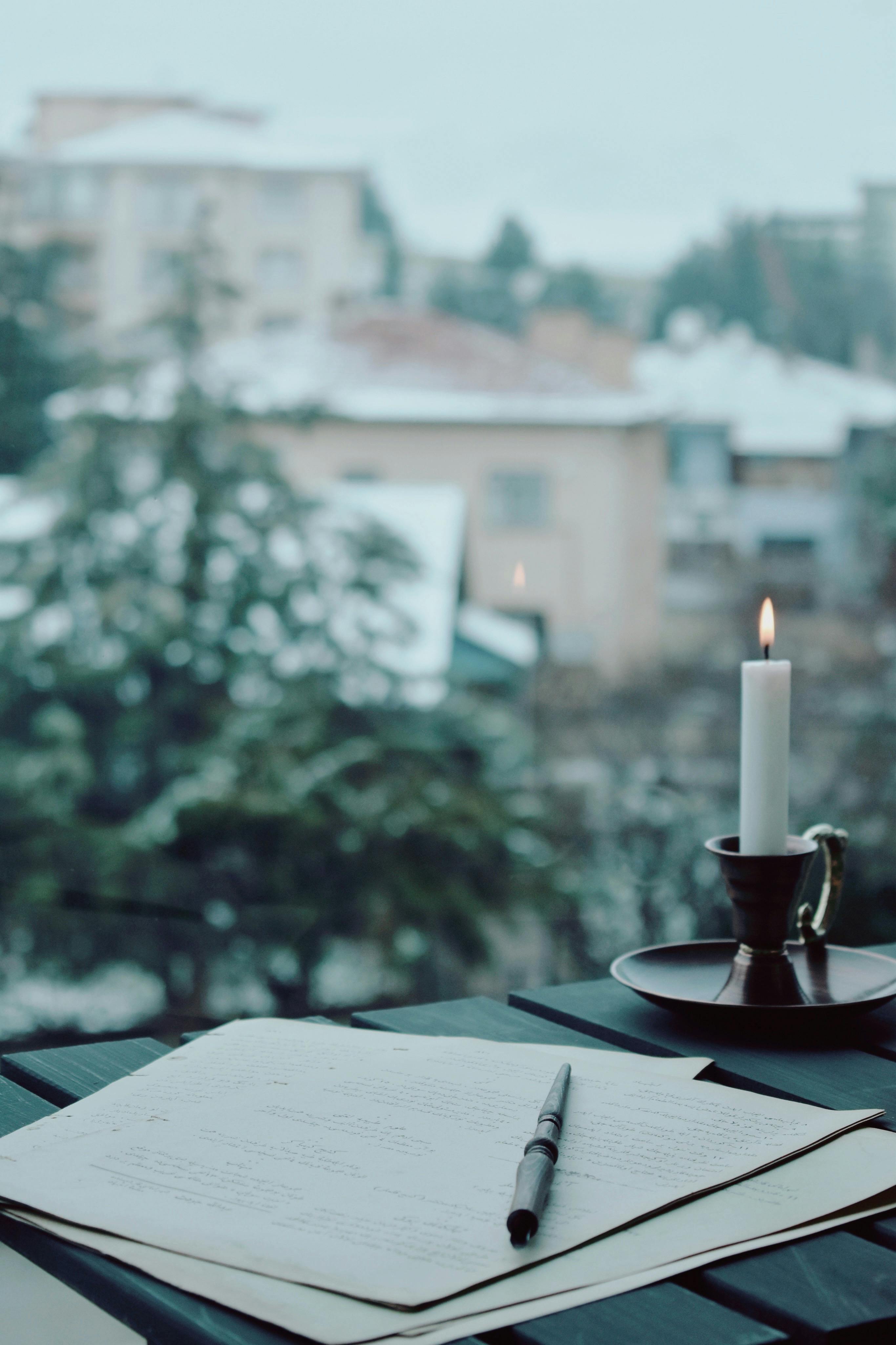 Cozy Winter Writing Scene with Candlelight · Free Stock Photo