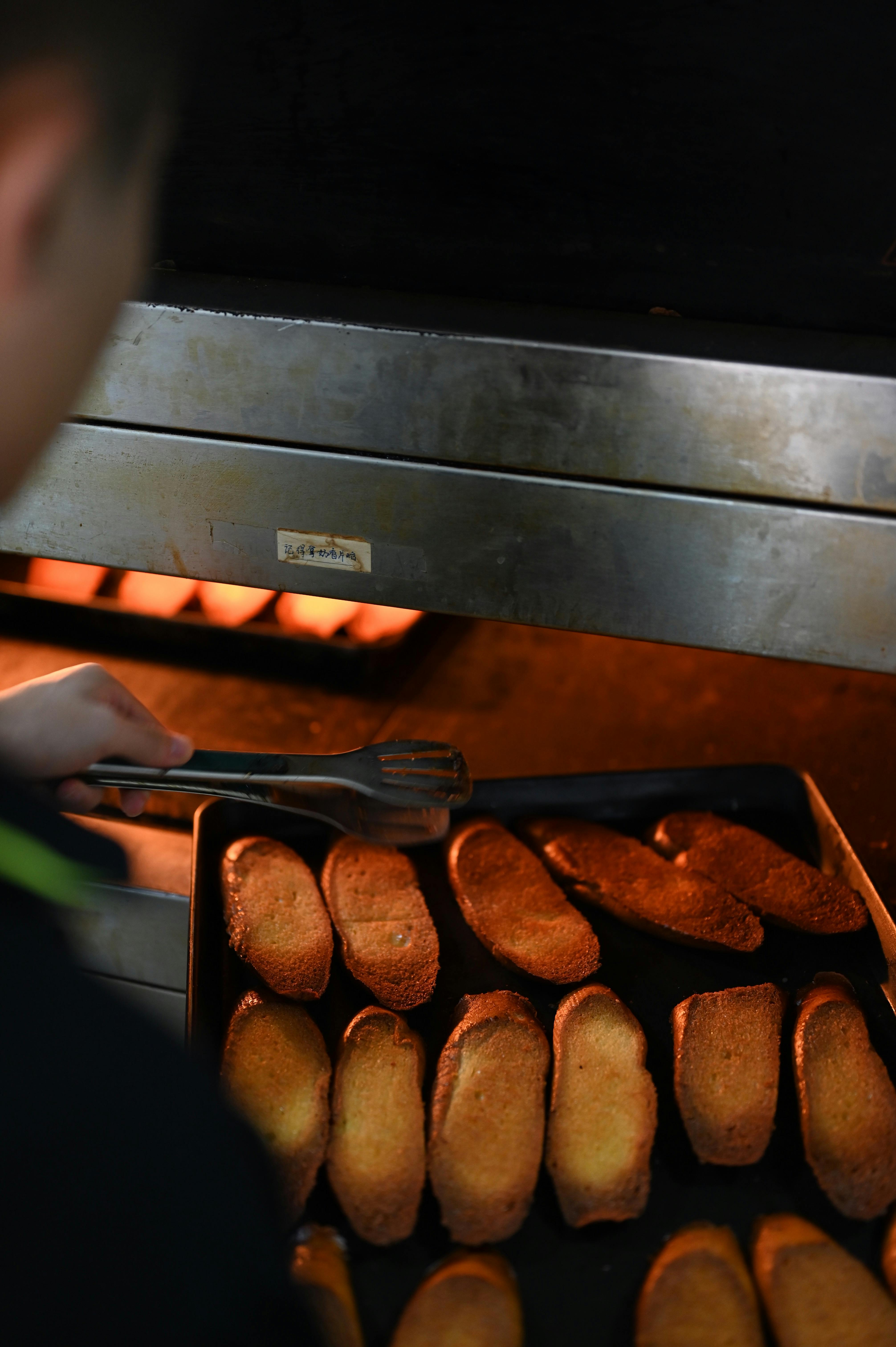 Baker Taking Freshly Toasted Bread from Oven · Free Stock Photo
