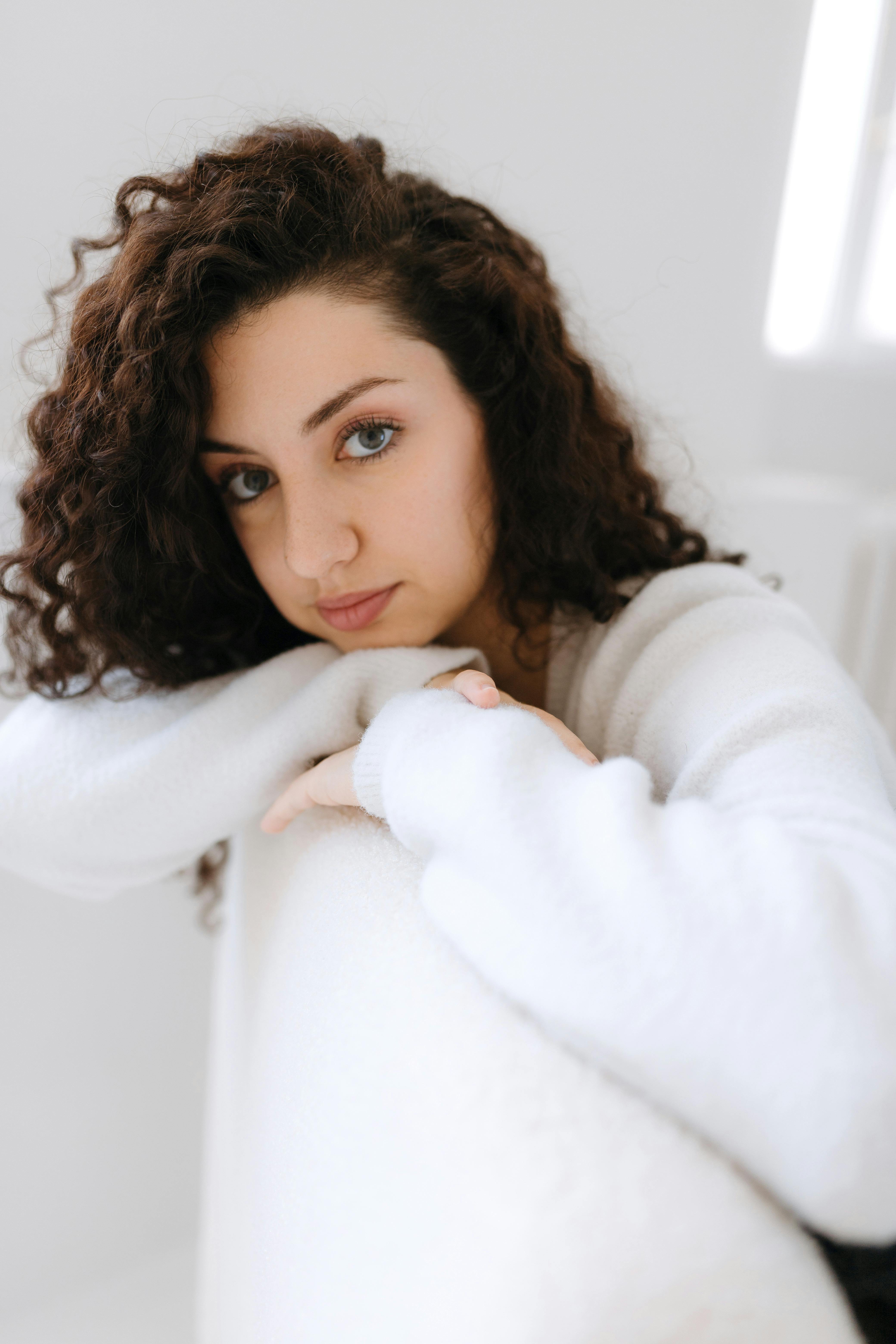 Woman in Cozy White Sweater Relaxing Indoors · Free Stock Photo
