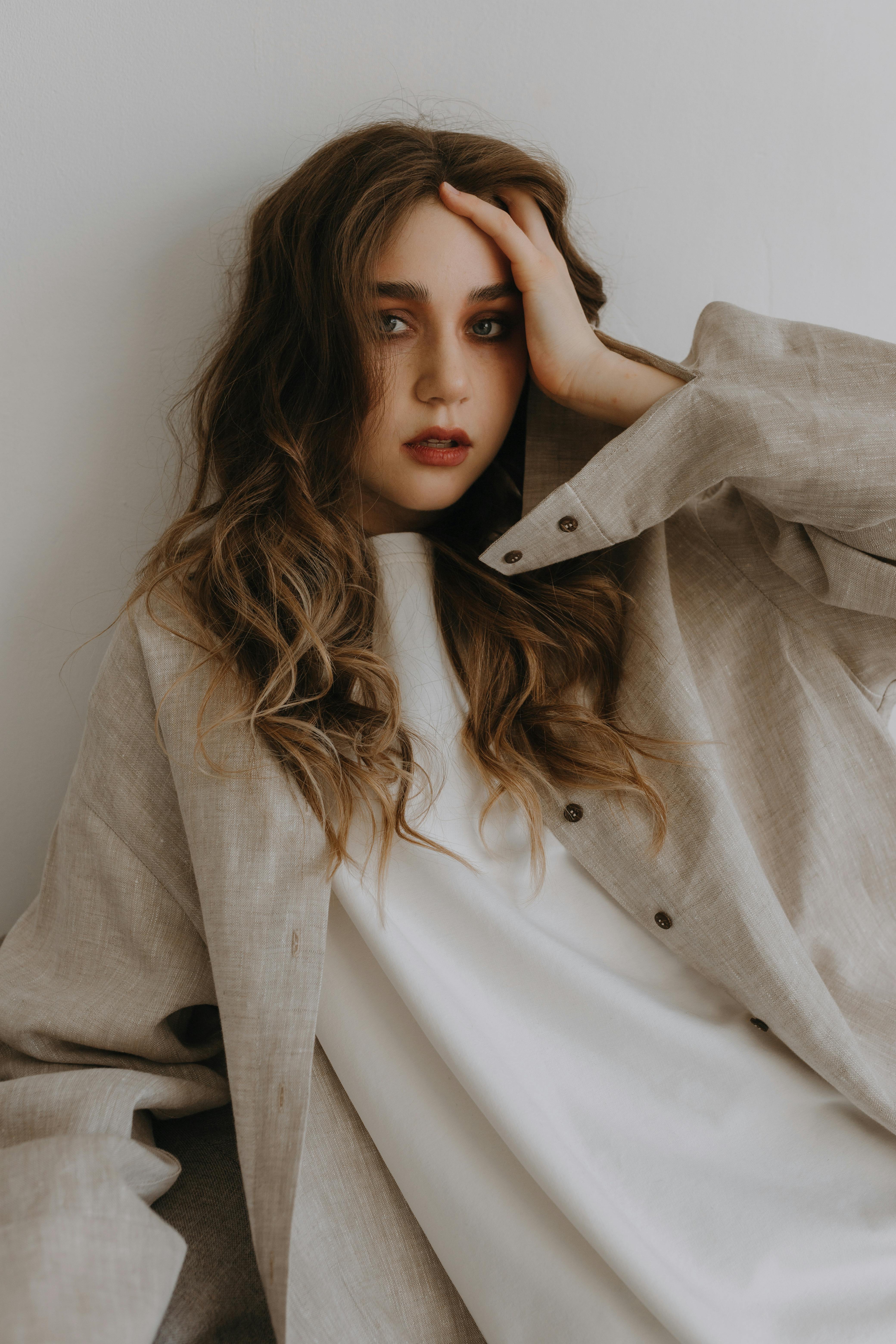 Contemplative Young Woman in Relaxed Fashion Pose · Free Stock Photo