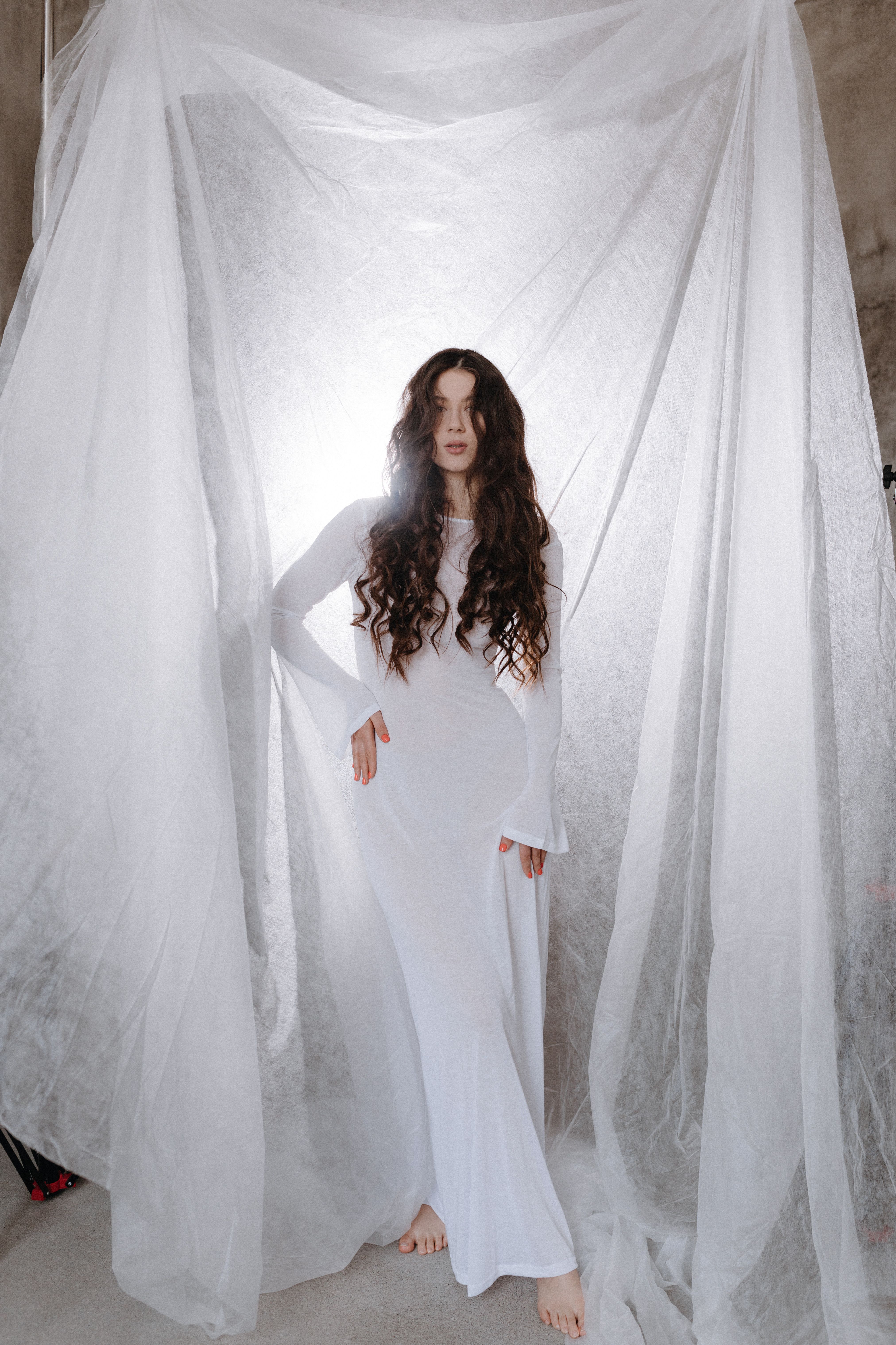 Elegant Woman in White Flowing Gown with Soft Lighting · Free Stock Photo