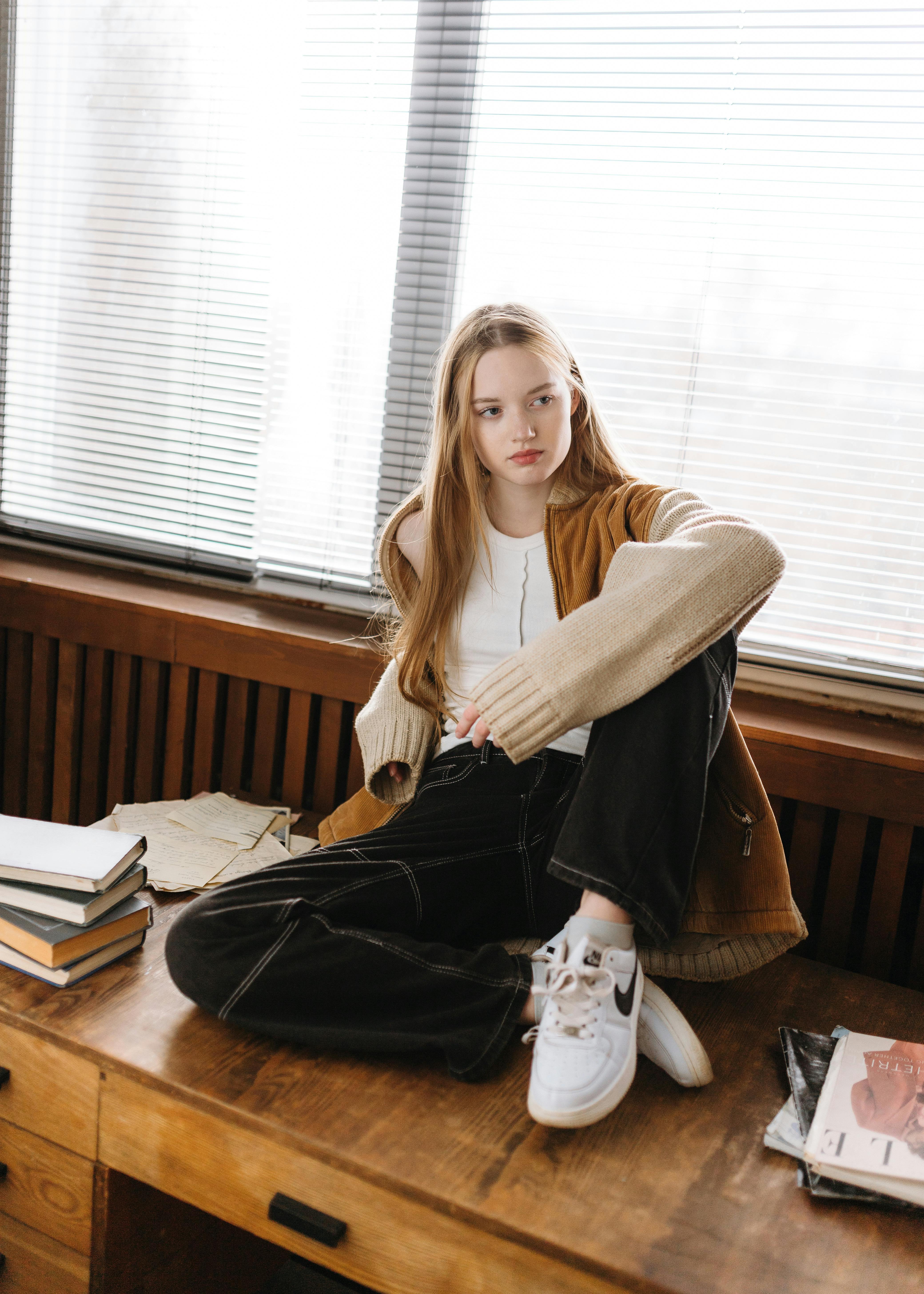 Young woman sitting casually reading indoors · Free Stock Photo