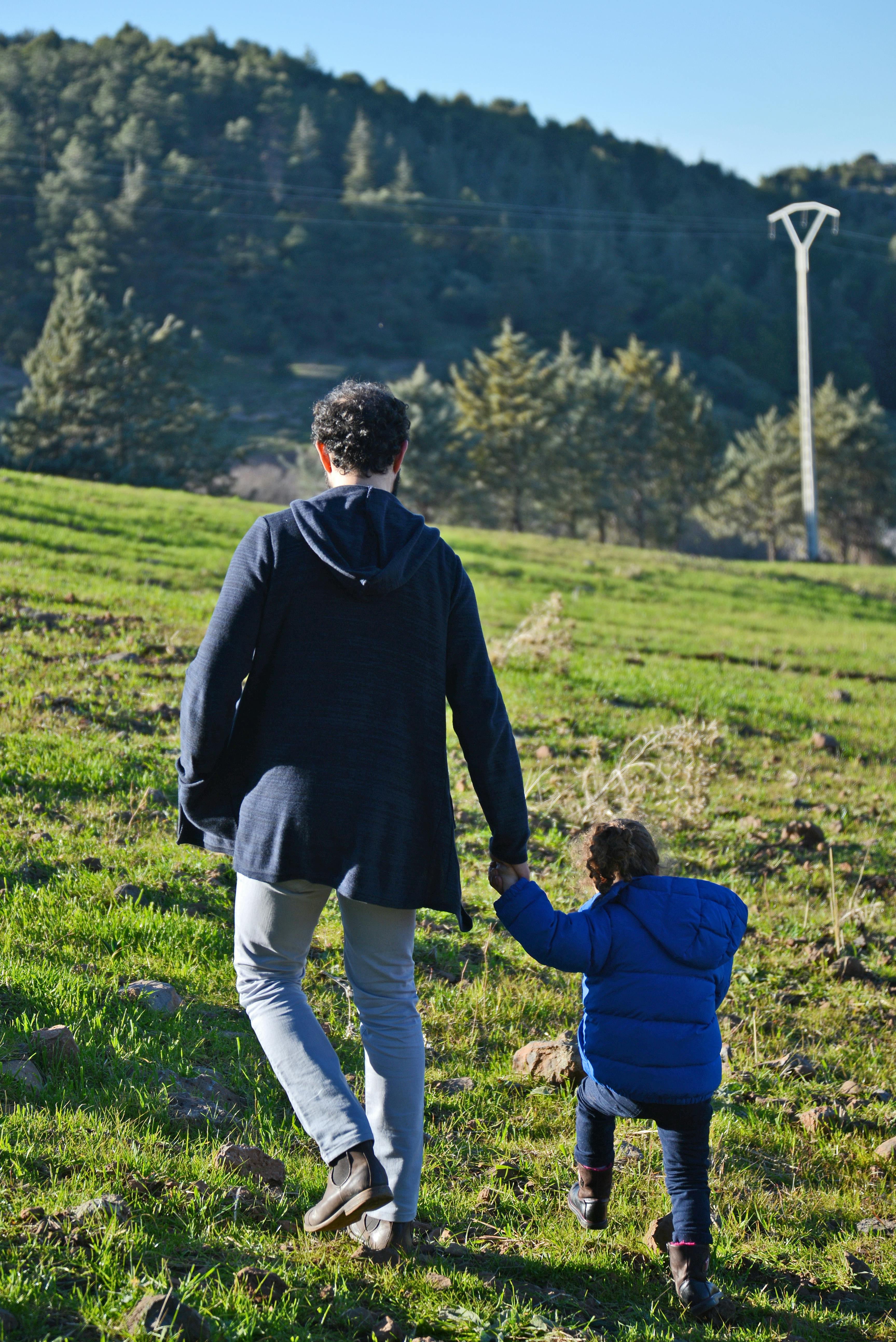 Father and Child Strolling in Azrou's Scenic Nature · Free Stock Photo