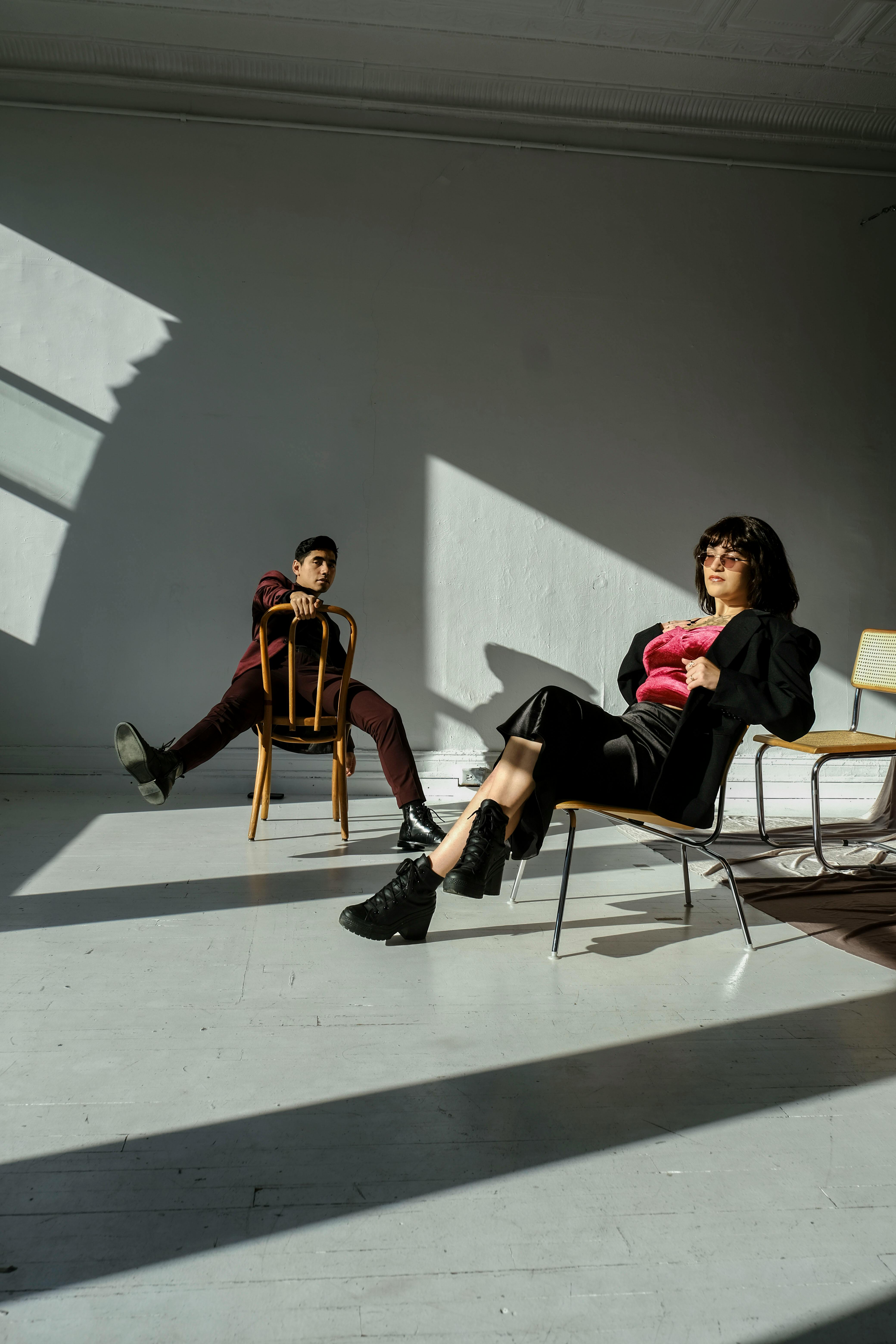 Two People Sitting on Chairs in Sunlit Room · Free Stock Photo
