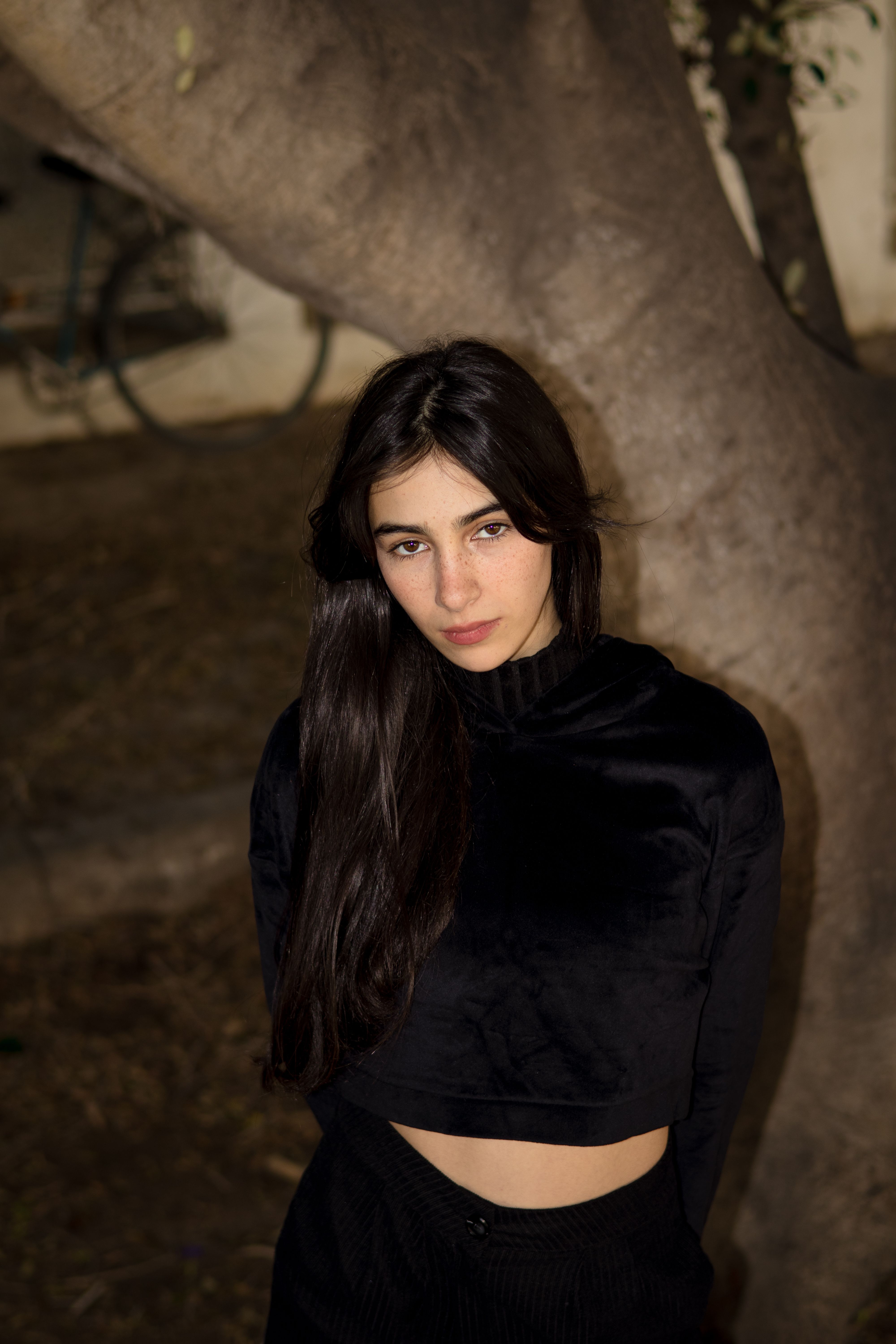 Young Woman Posing Outdoors Under a Tree · Free Stock Photo