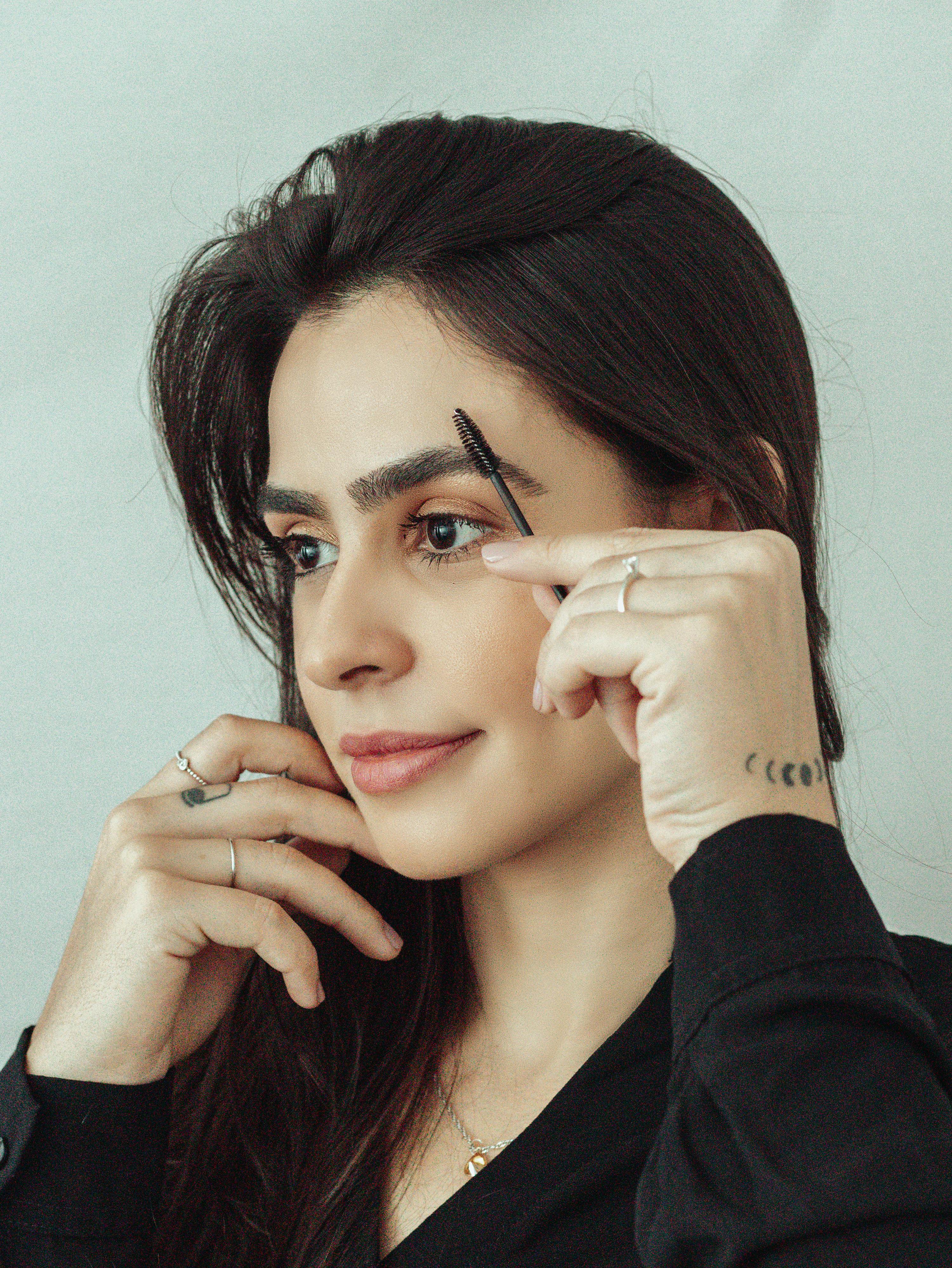 Woman grooming eyebrows with a brush at home · Free Stock Photo