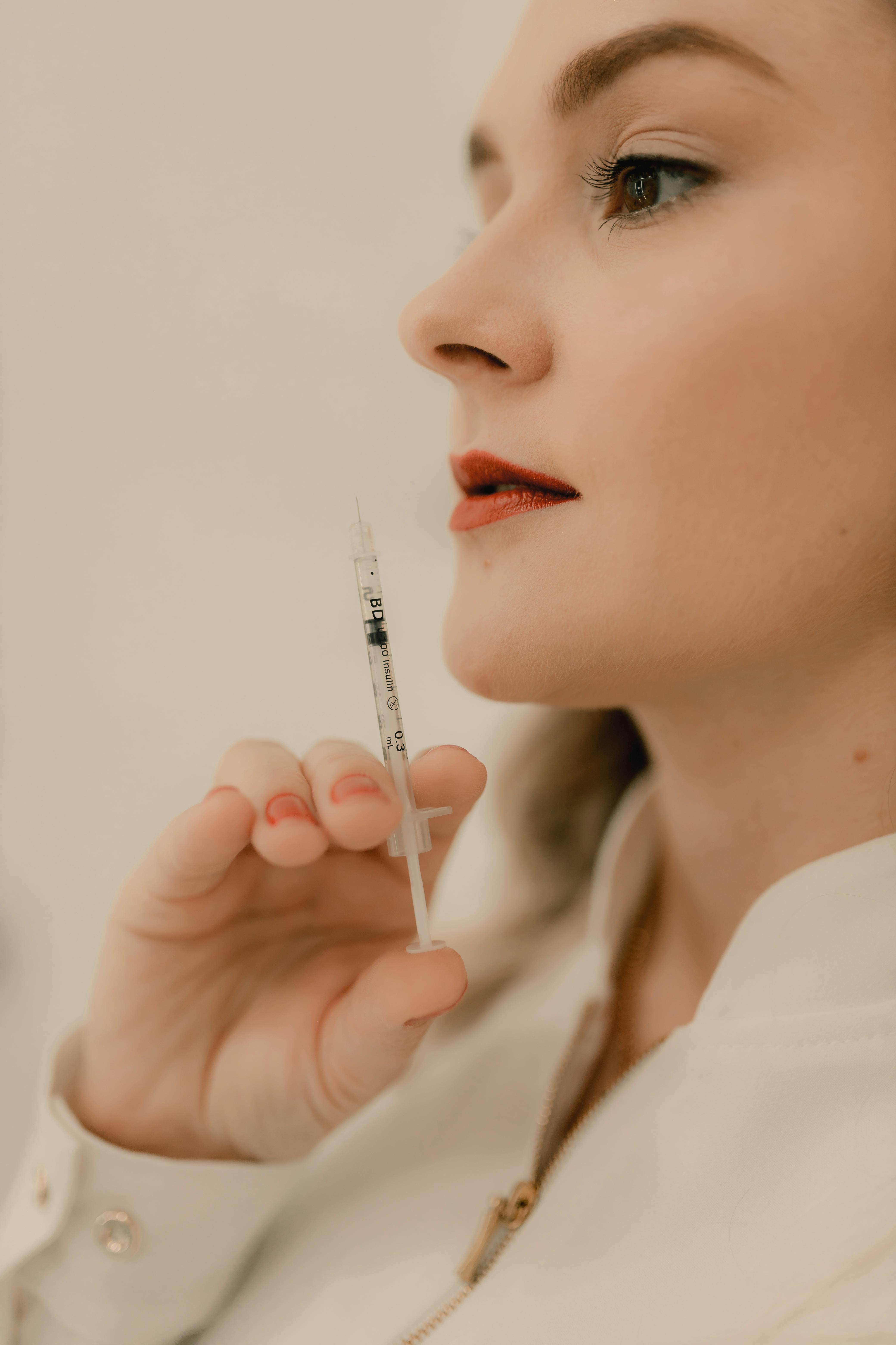 Close-Up of Woman Holding a Syringe · Free Stock Photo