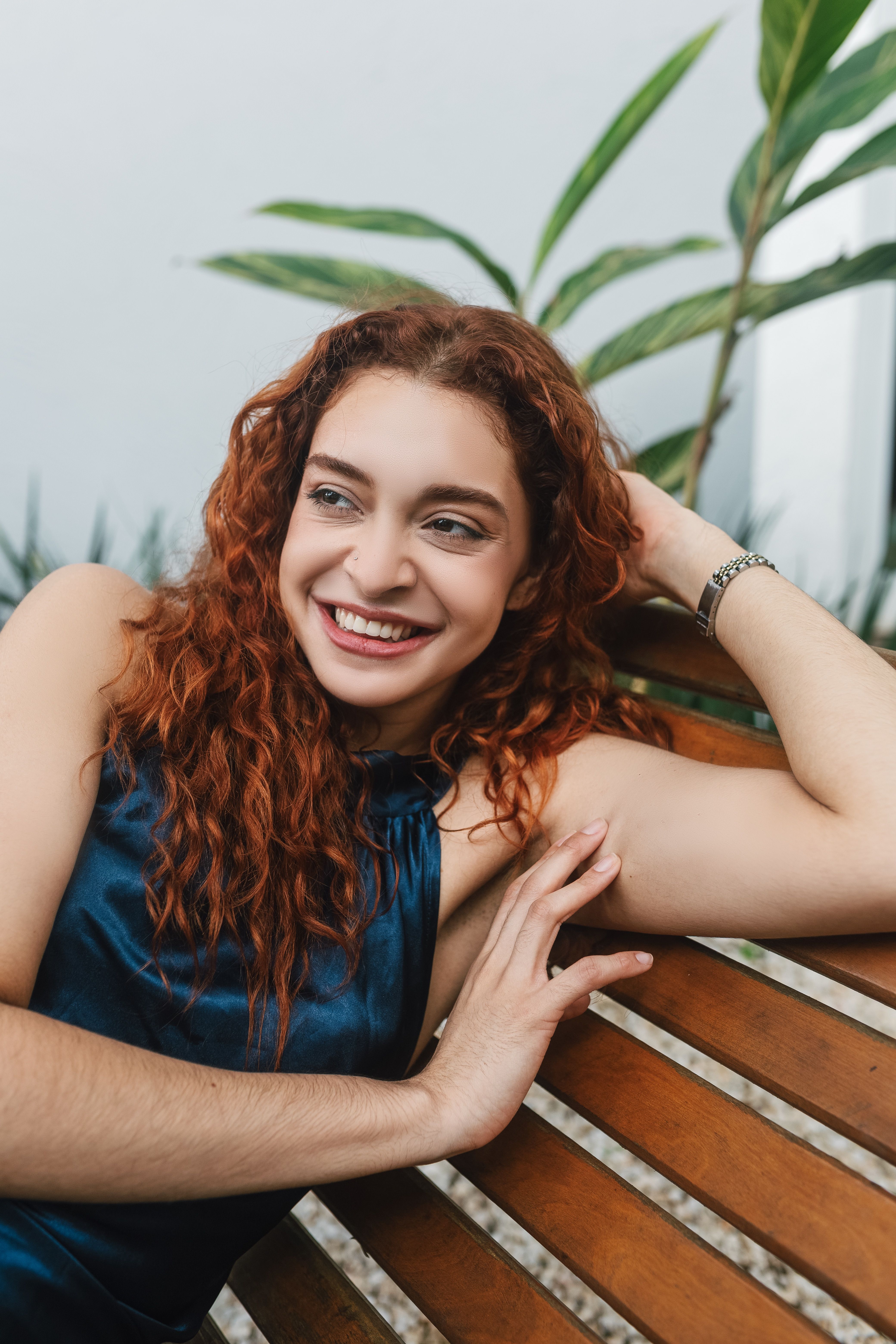 Smiling Woman Relaxing on Wooden Bench Indoors · Free Stock Photo