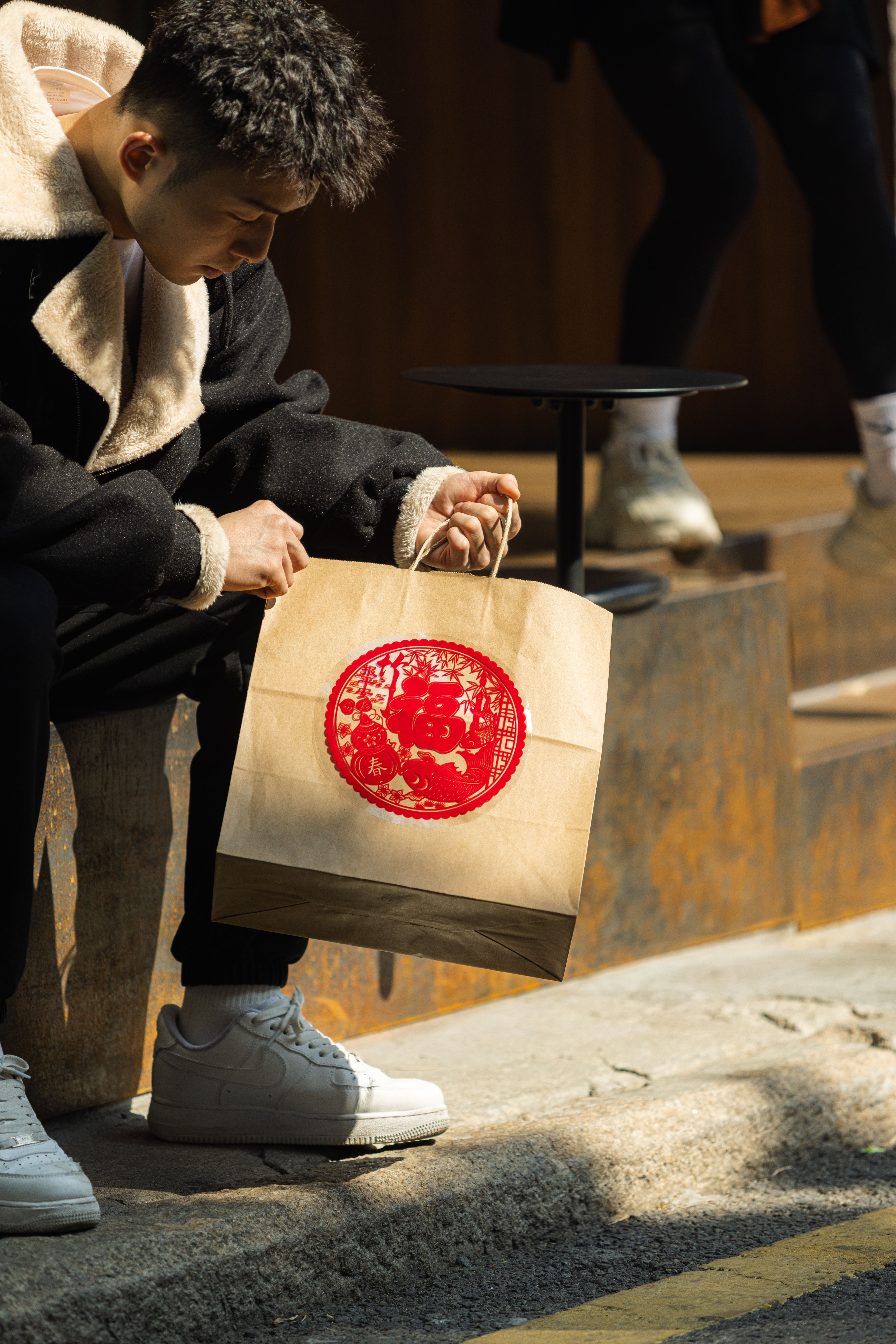 Man Holding Paper Bag with Chinese Symbol Outdoors · Free Stock Photo